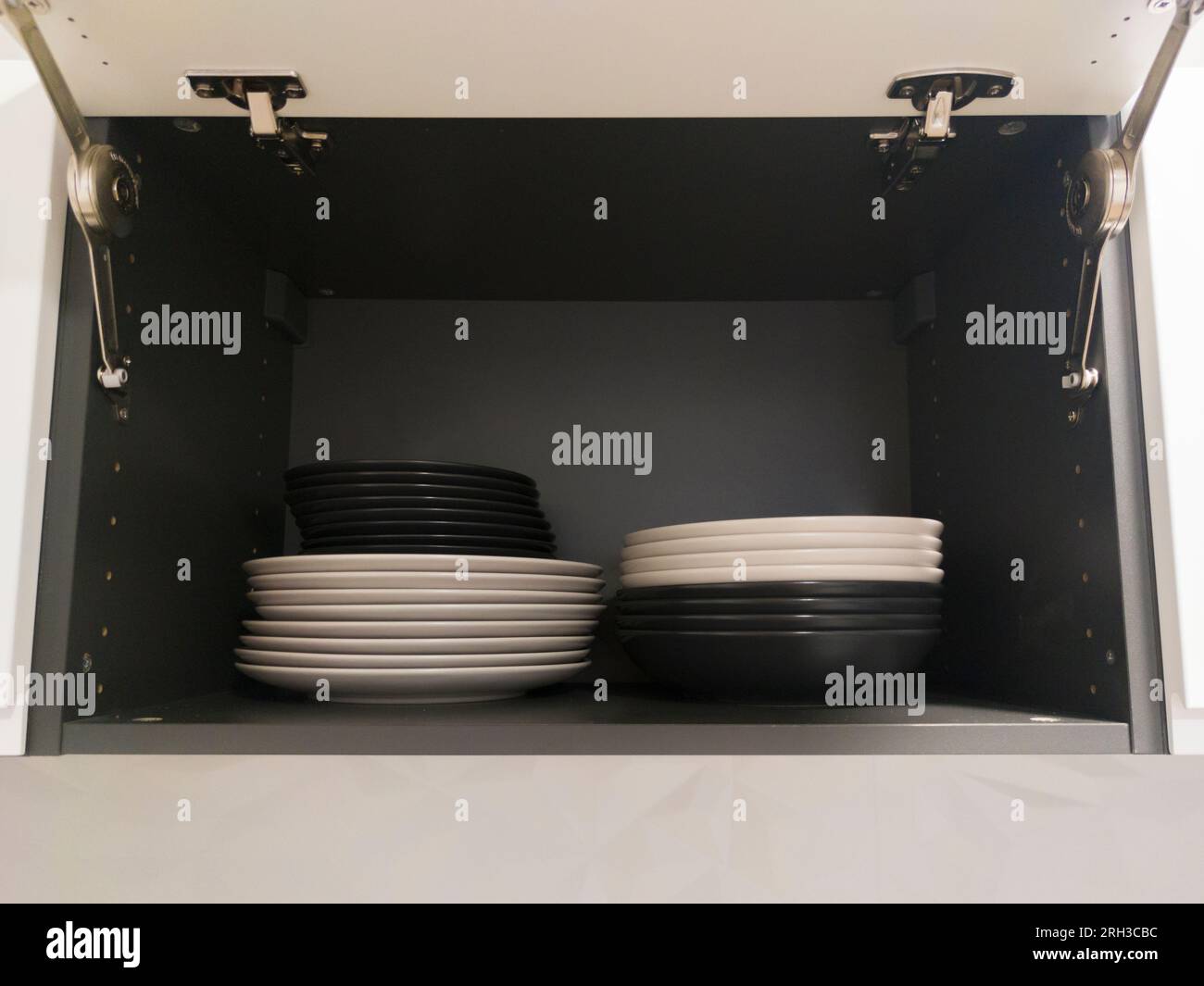 Top kitchen cupboard showing dishware. Handleless cupboards concept ...