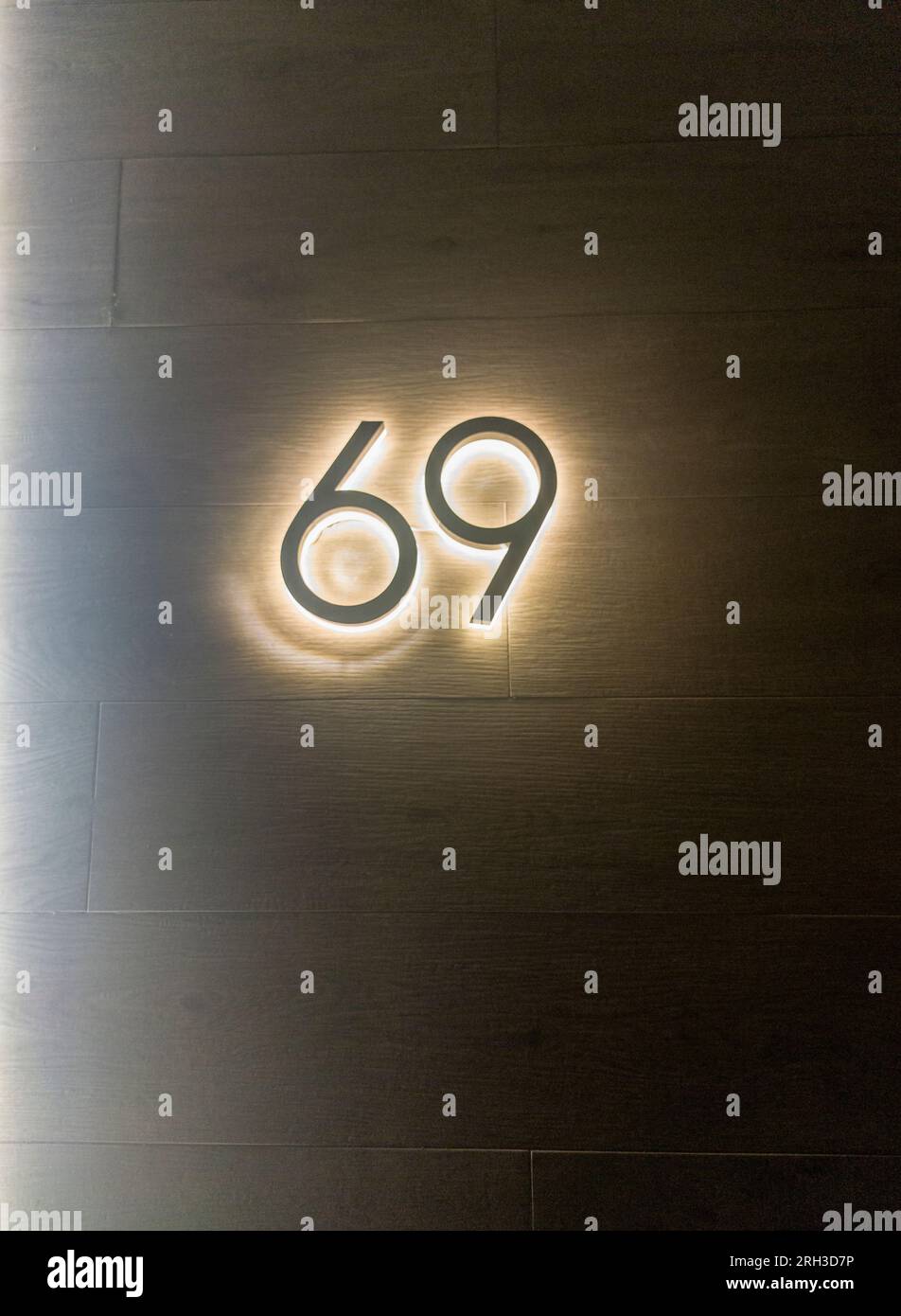 House number 69 backlit with wood effect tile background. Houses with ...