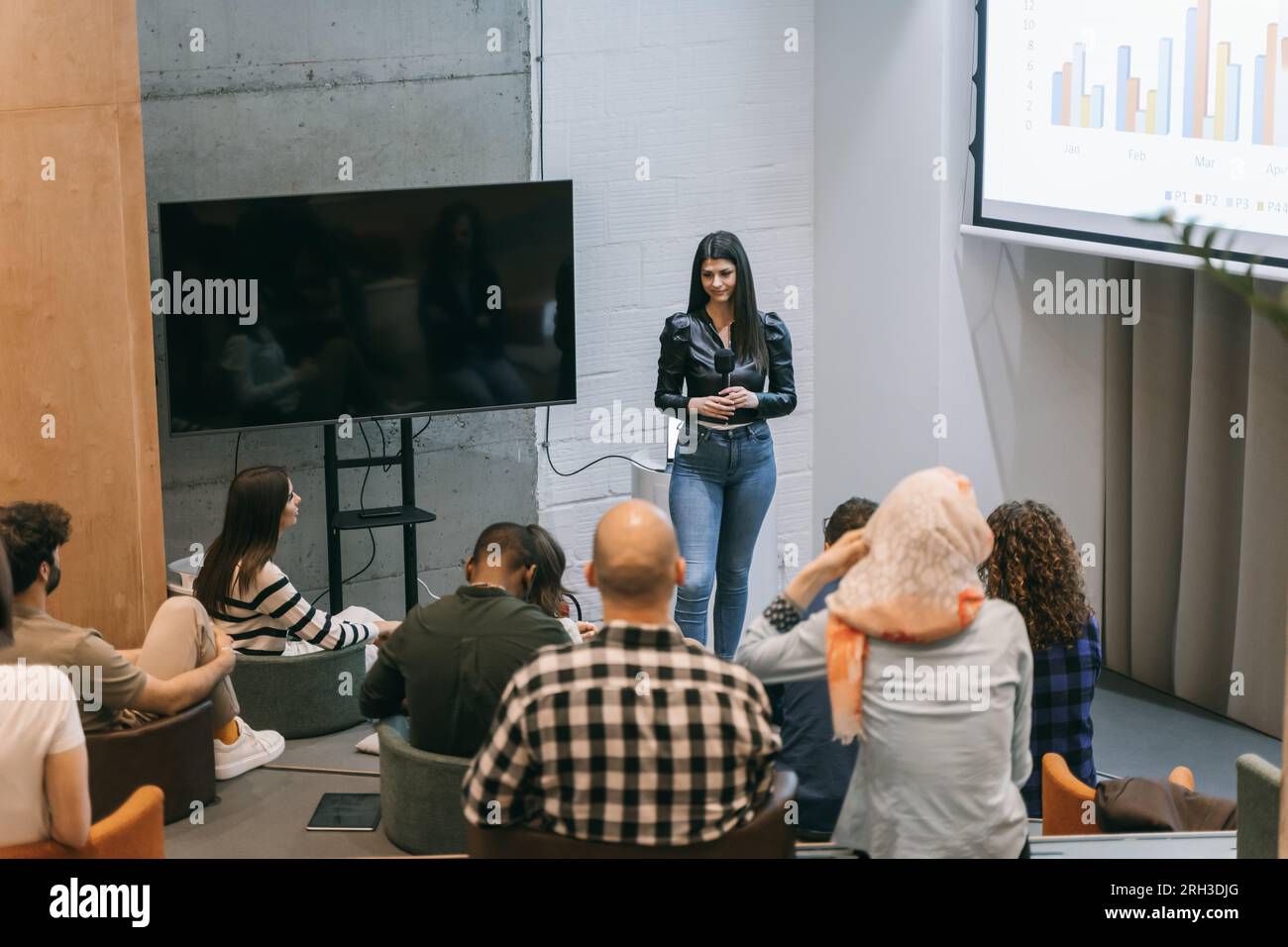 Young and beautiful business woman smiling and presenting a graph to a ...