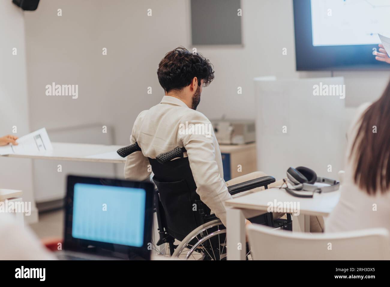 Handicapped business coach rolling wheelchair wheel, taking his ...