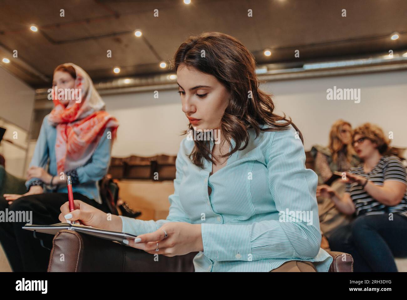 Stunning, female, business employee writing information down in a ...