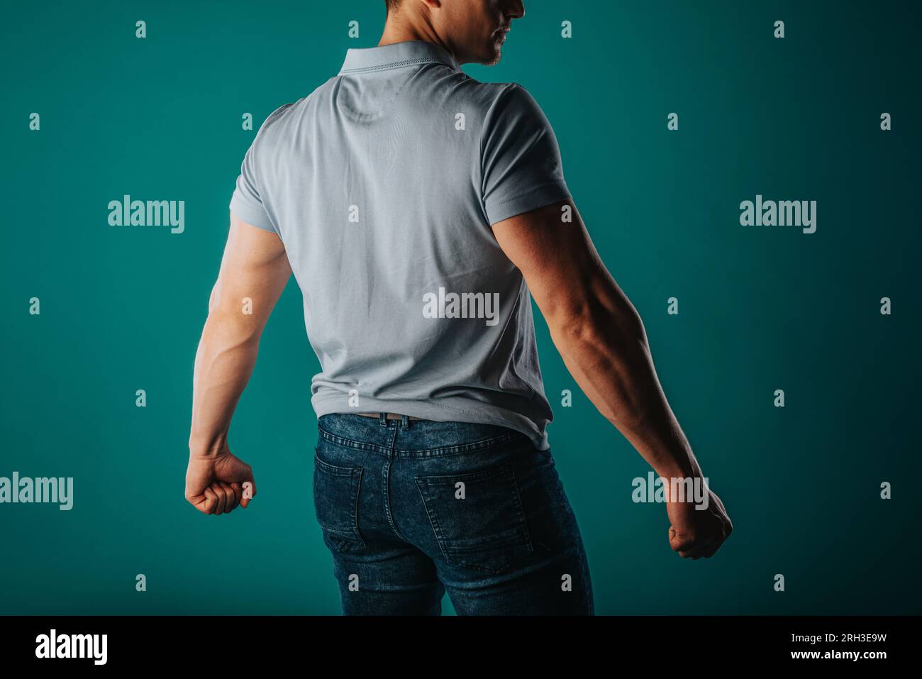 Well-built and charming man standing in front of a green background and ...