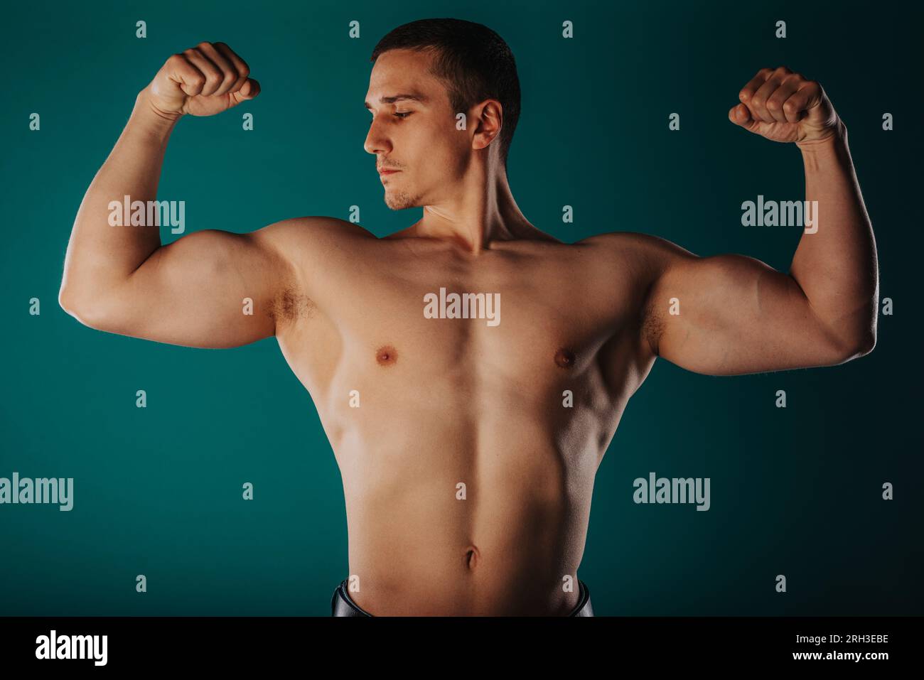 Aesthetic man standing in a green room and flexing his biceps Stock ...