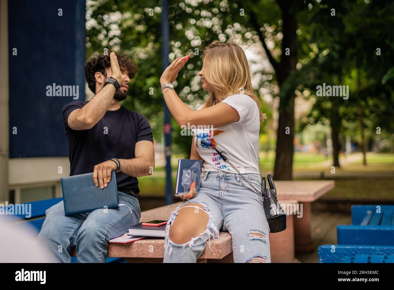 Happy students giving high five each other after they successfully ...
