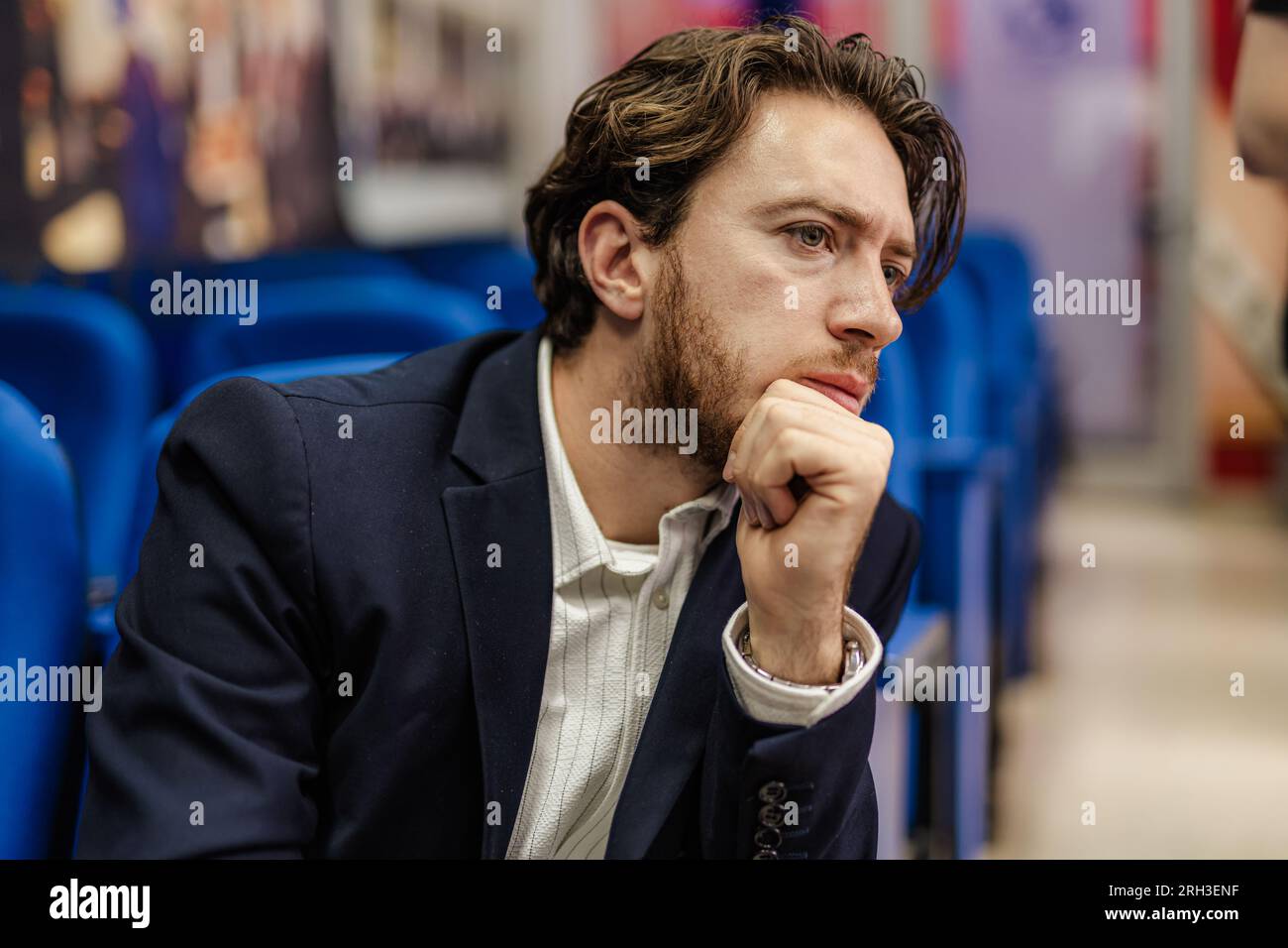 Male student looking very focused and deeply thinking while sitting in ...