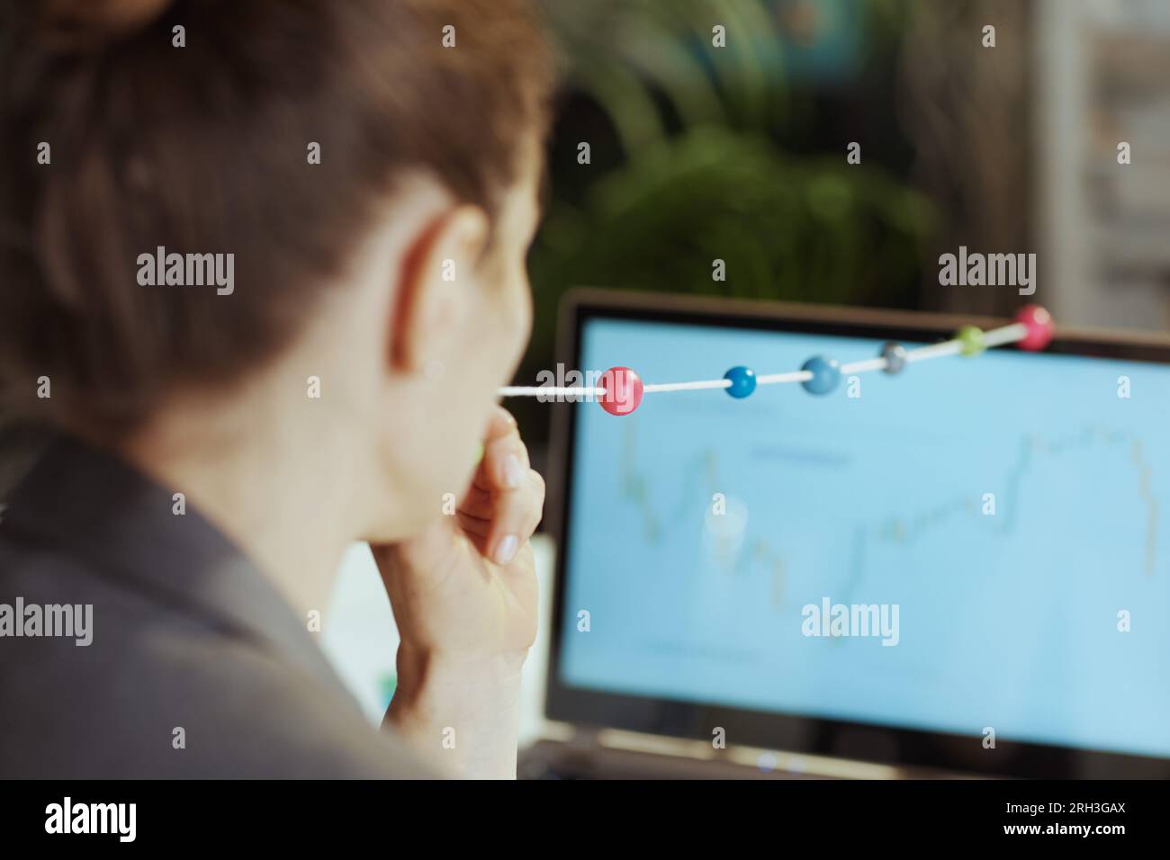 Sustainable workplace. Seen from behind modern business woman in a grey ...