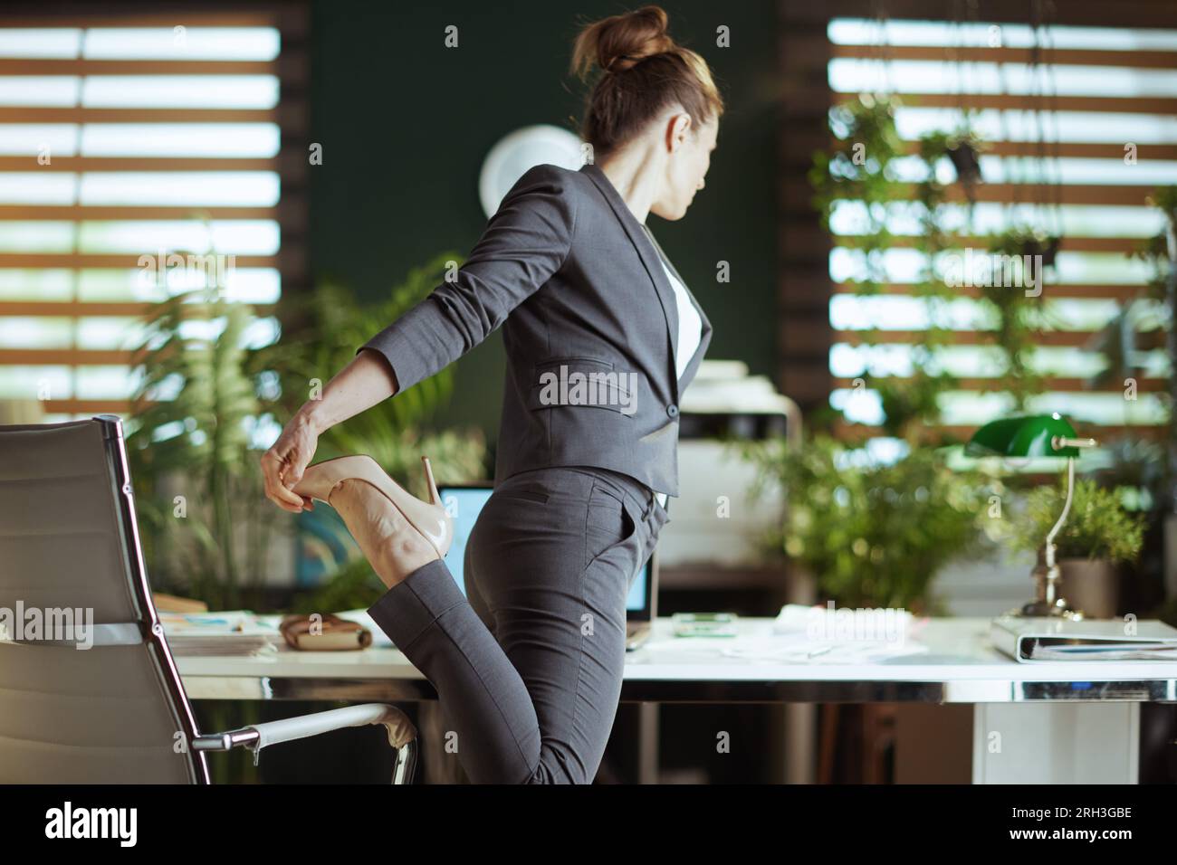 Sustainable workplace. Seen from behind modern business woman in a grey ...