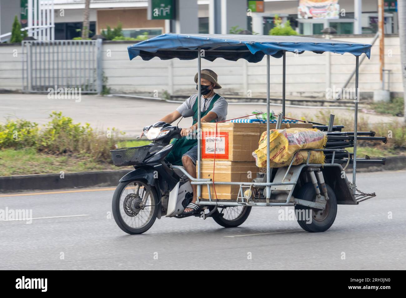 RATCHABURI, THAILAND, OCT 18 2022, A man drives a motorcycle with an ...