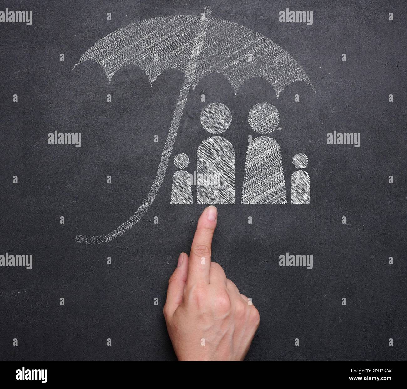 A family drawn in white chalk under an umbrella on a black chalkboard ...
