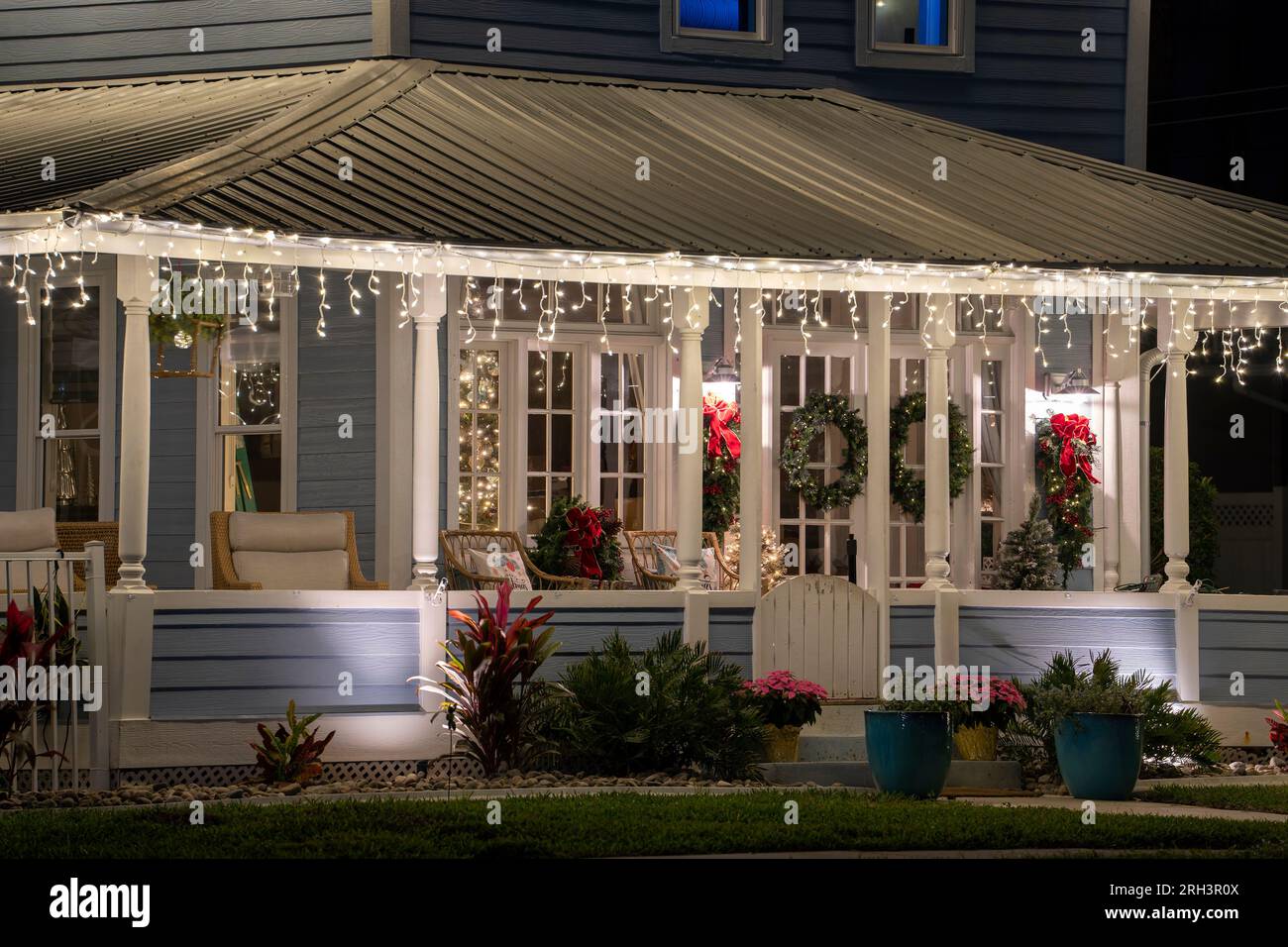 Brightly illuminated christmas decorations on front yard porch of ...