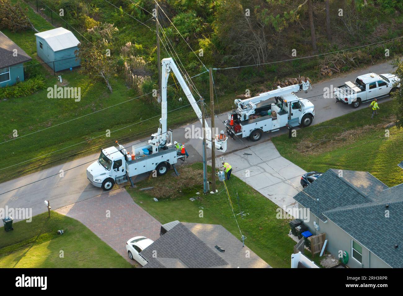 Electrician workers repairing damaged power lines using bucket trucks ...