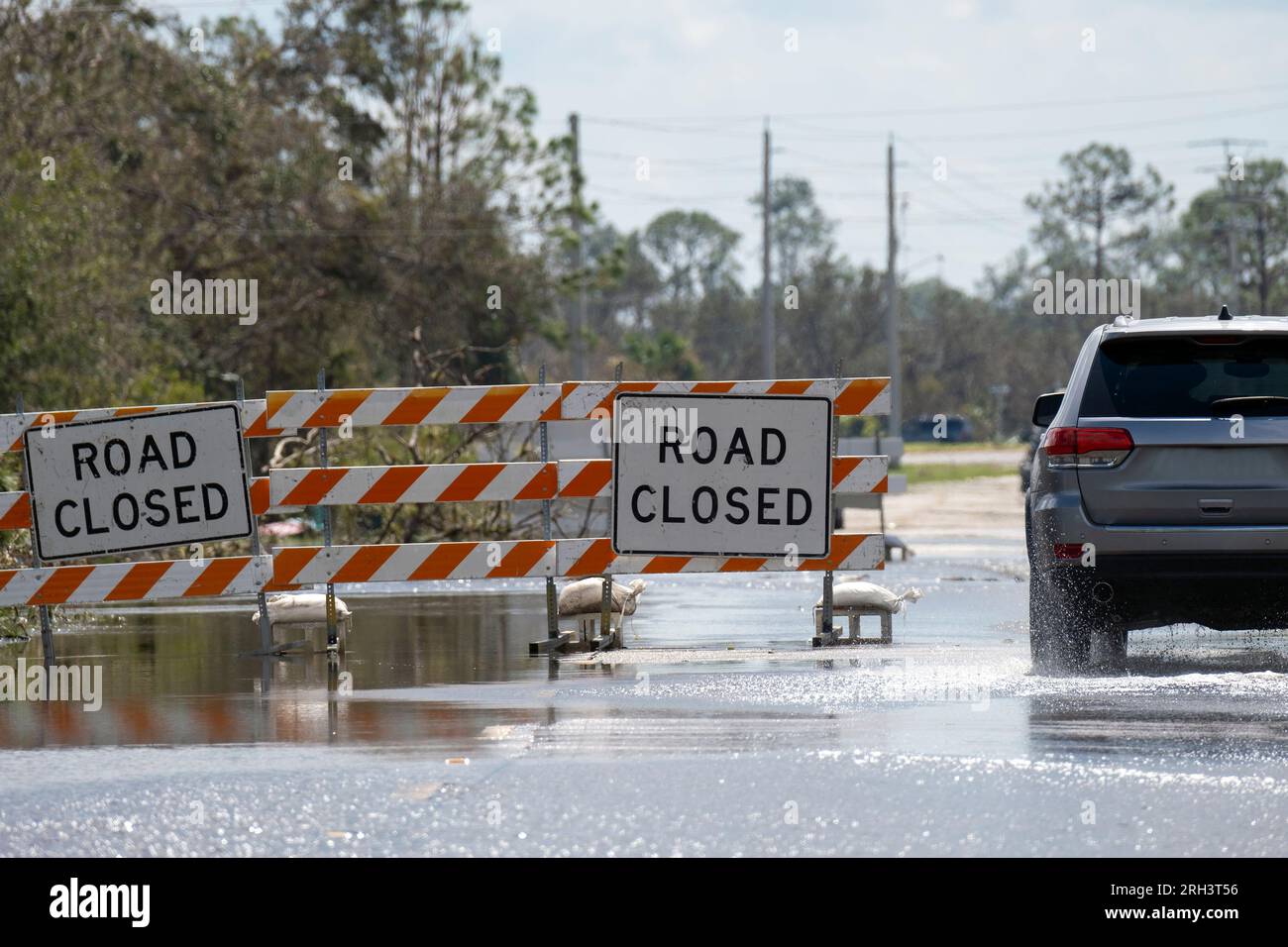Hurricane flooded street with road closed signs blocking driving of ...