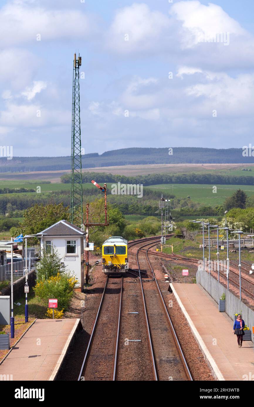 Railway track tamping machine passing the mechanical signal box and ...