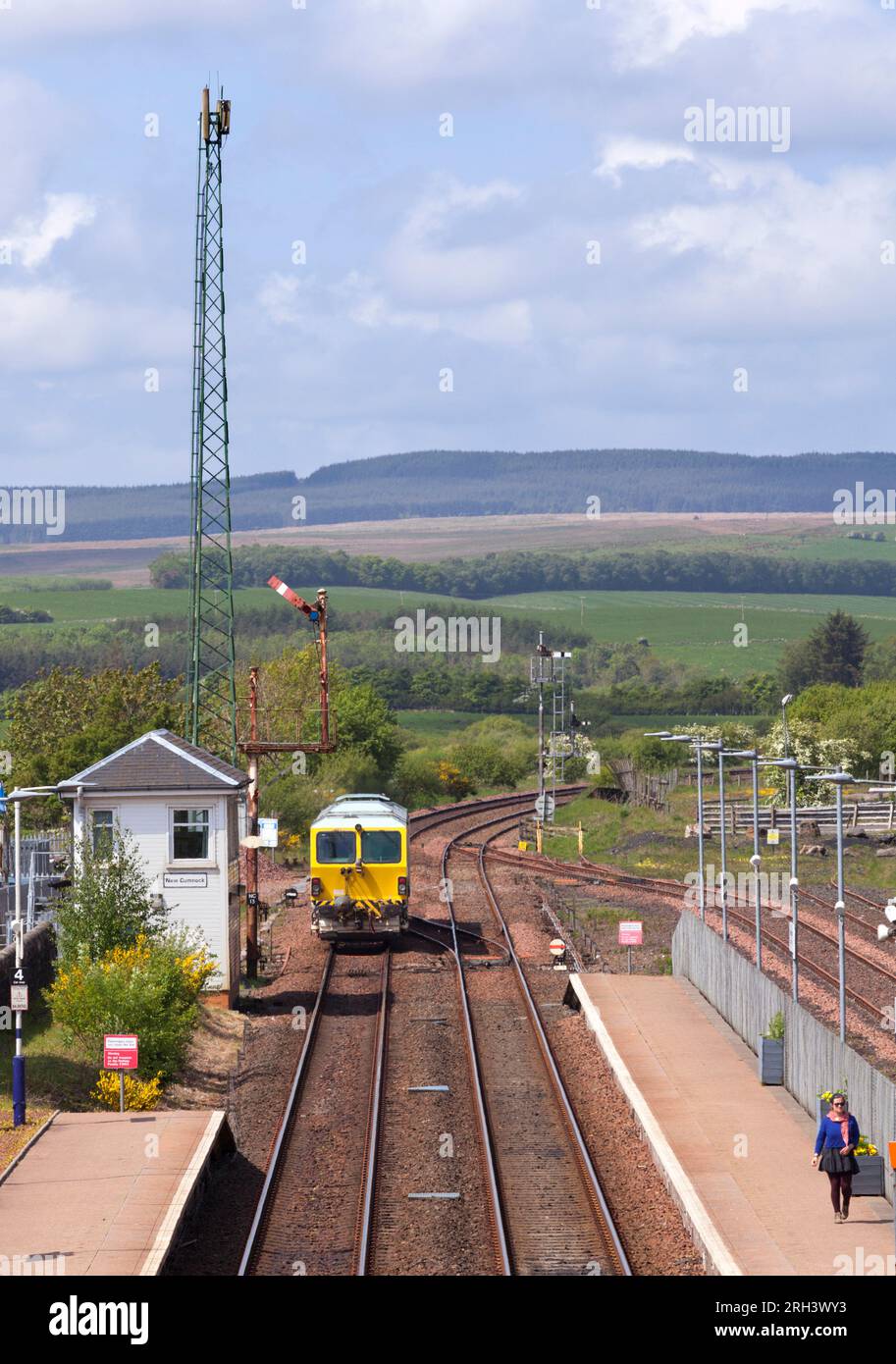 Railway track tamping machine passing the mechanical signal box and ...
