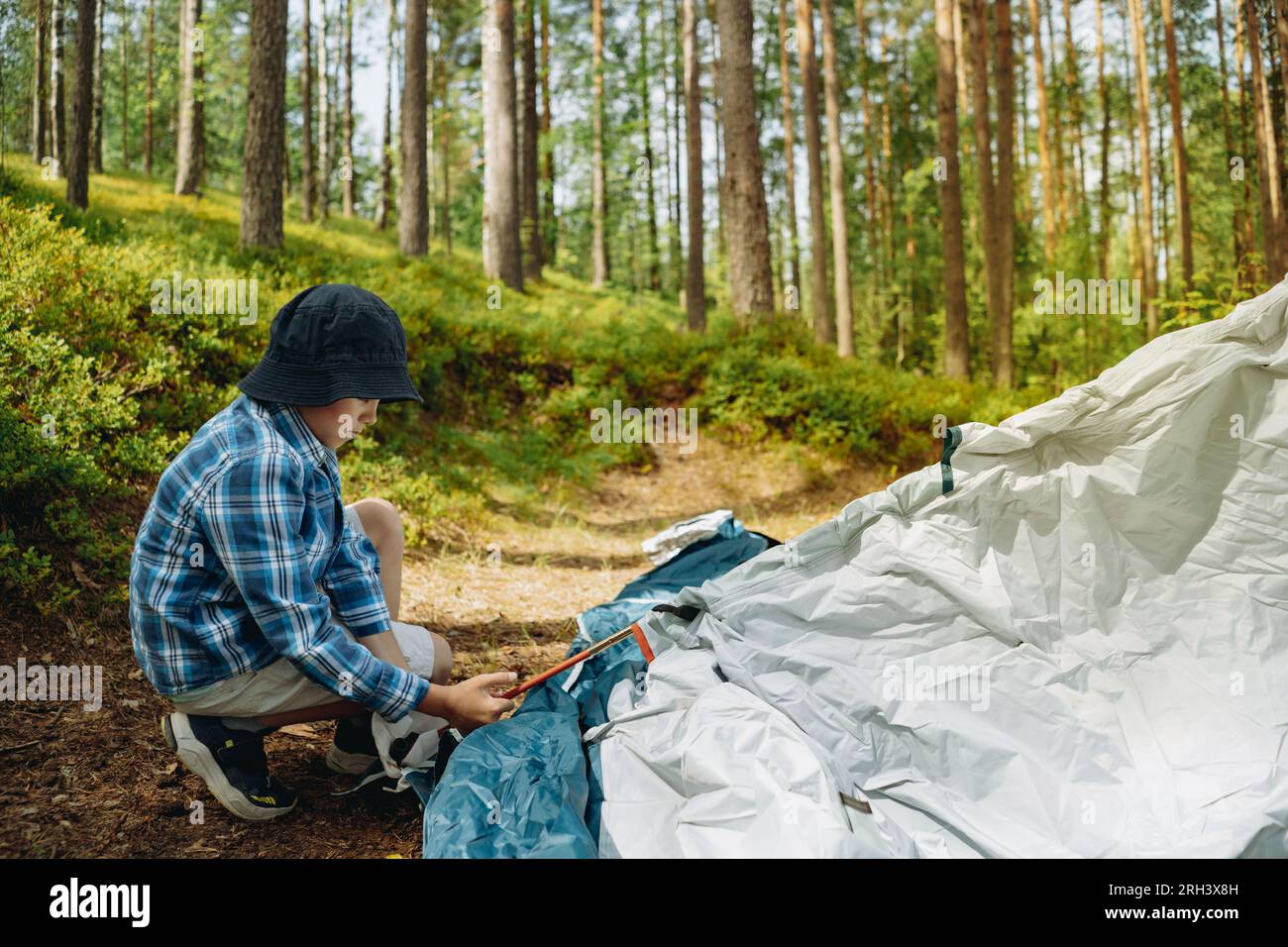 cute little caucasian boy putting up a tent. Family camping concept. Image with selective focus ...