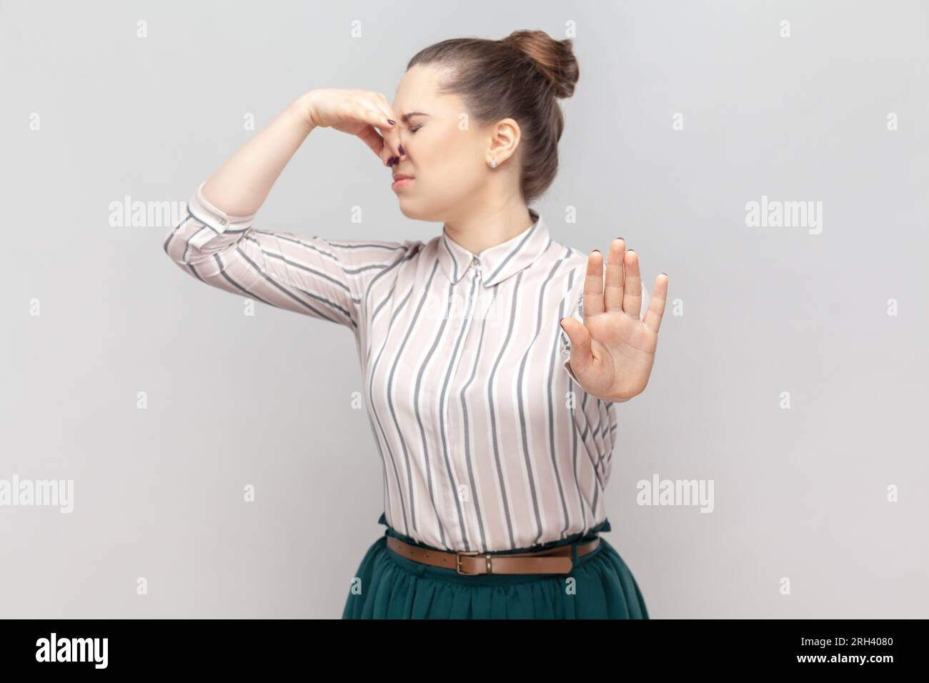 Portrait of disgusted attractive woman wearing striped shirt standing ...