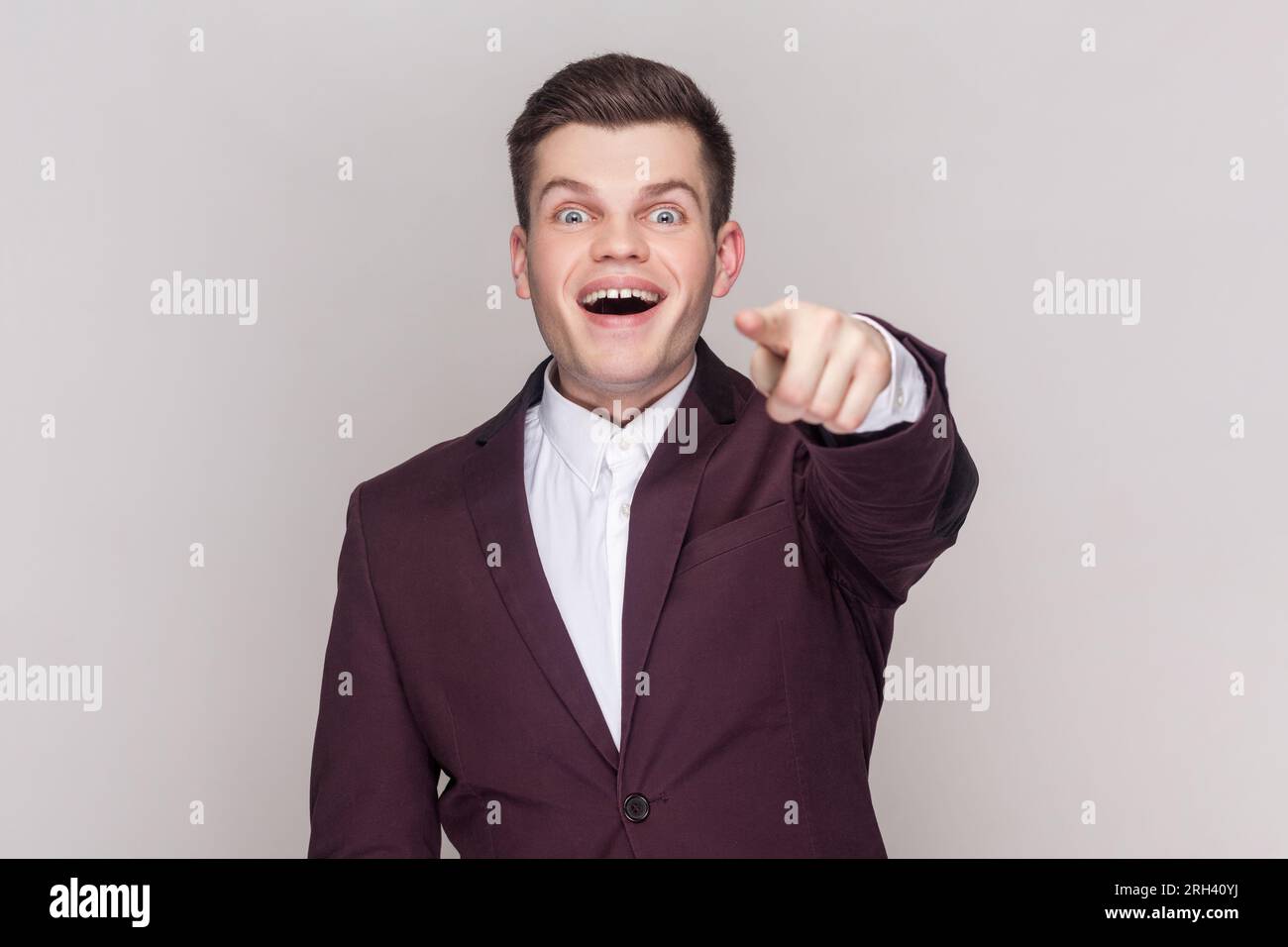 Portrait of playful handsome young man makes finger gun gesture at ...