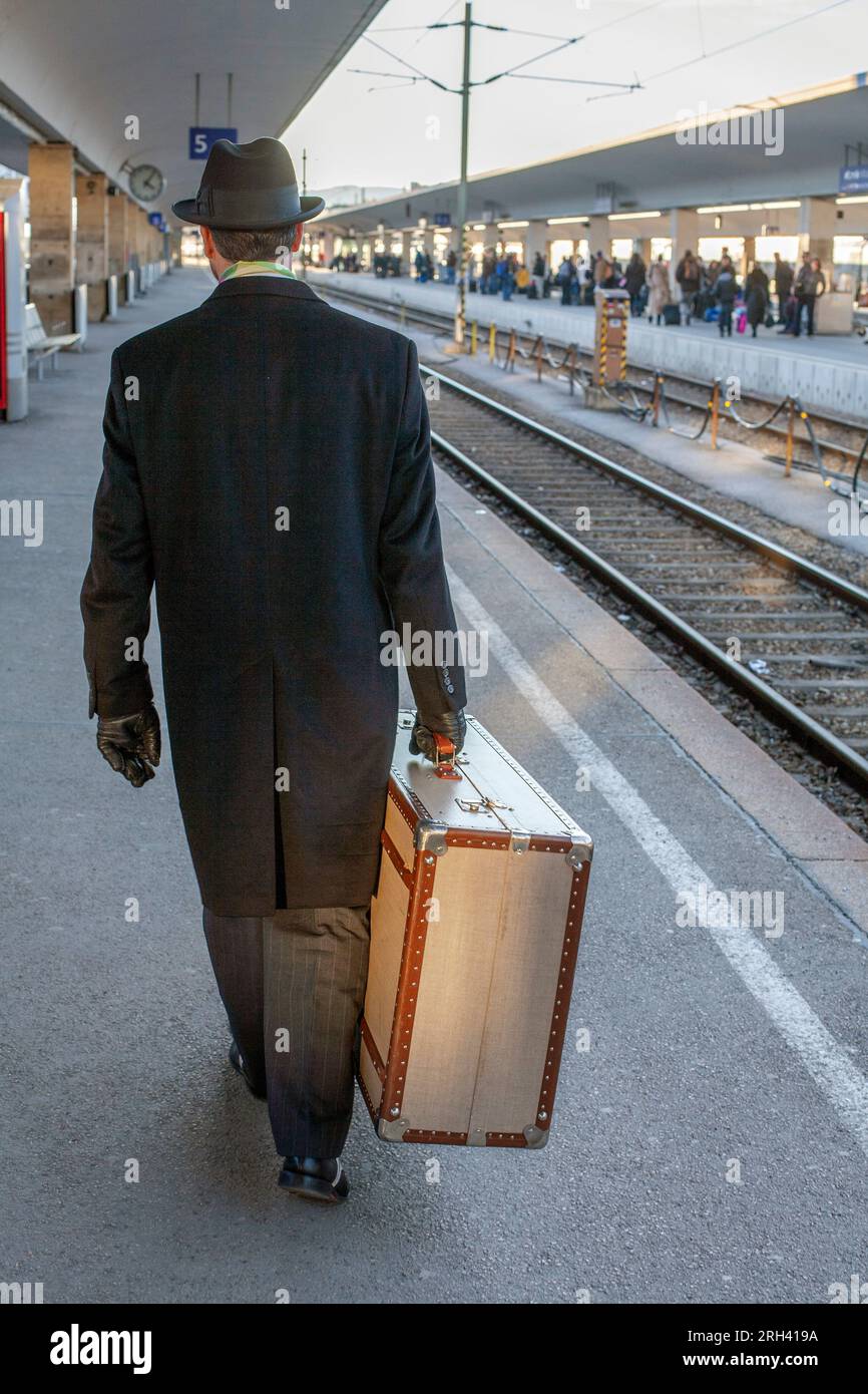 Man walking with suitcase at railways station. Male walking down the ...