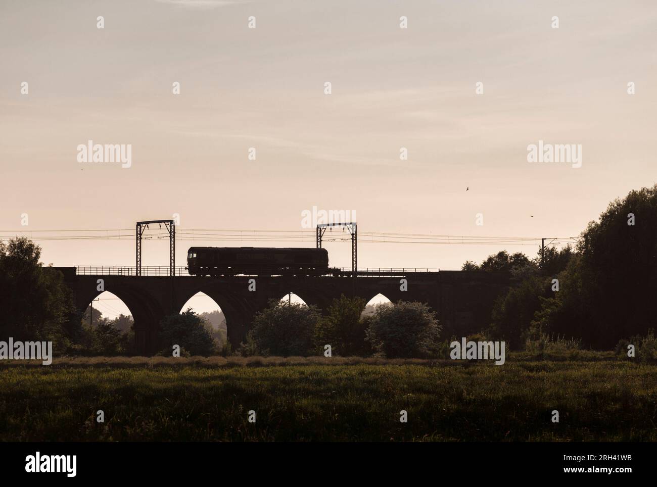 Sillhouette of a DB Cargo rail UK class 66 locomotive (66063) crossing ...