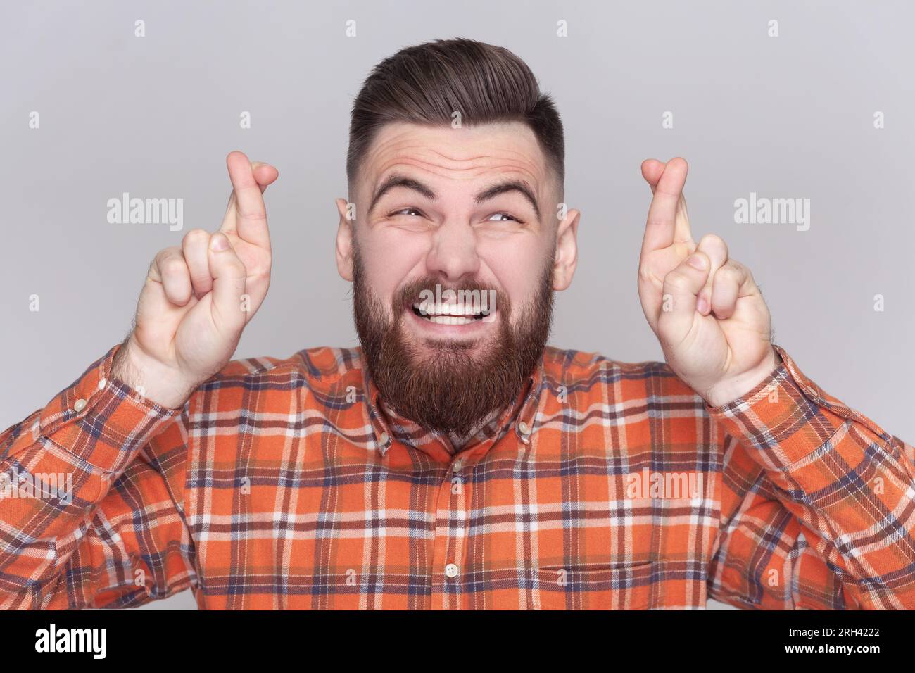 Portrait of funny positive bearded man standing with clenched teeth and ...
