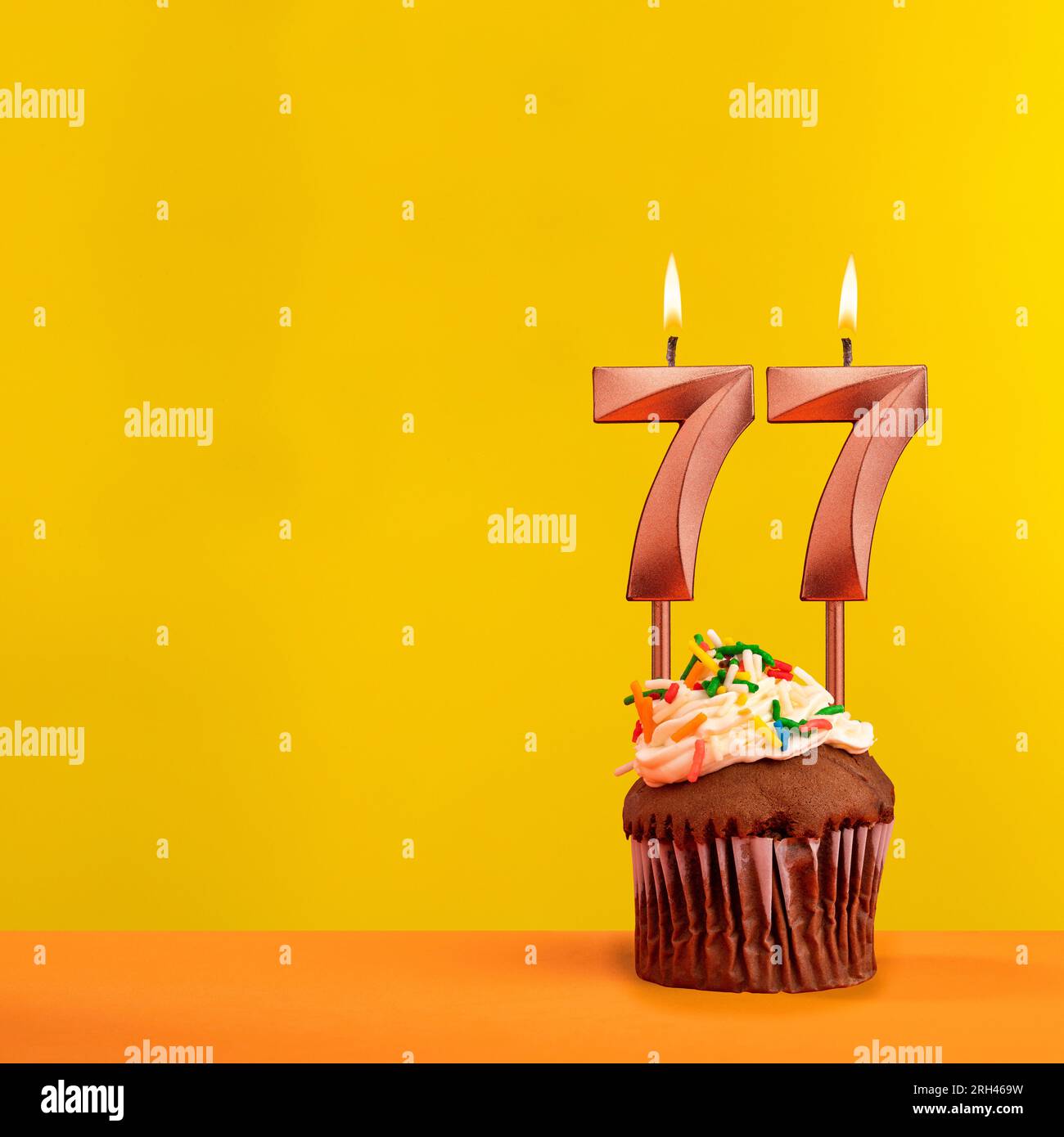 Candle with flame number 77 - Birthday card on yellow background Stock ...