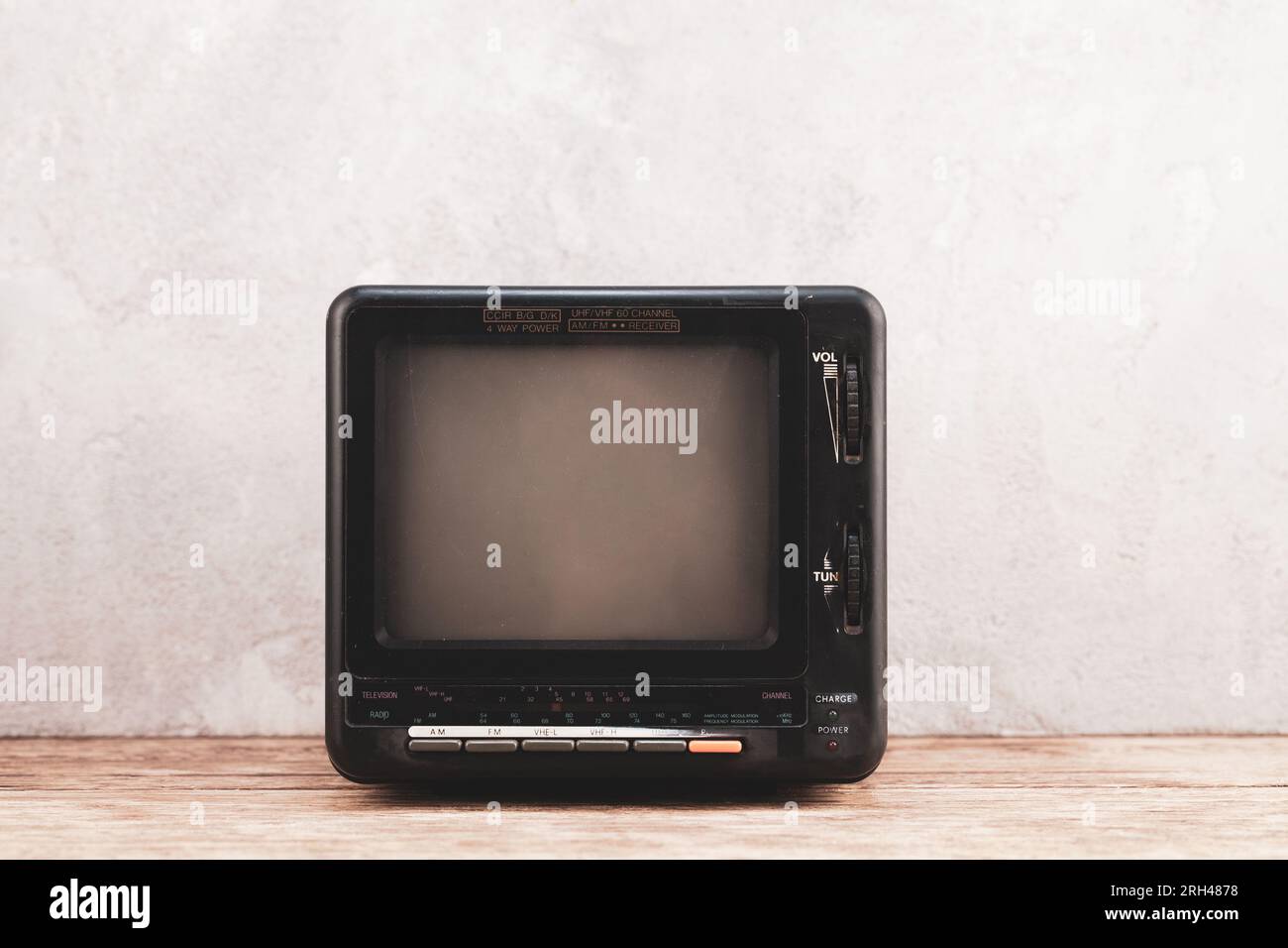 Vintage retro analog small TV set stand on wooden floor front grey ...