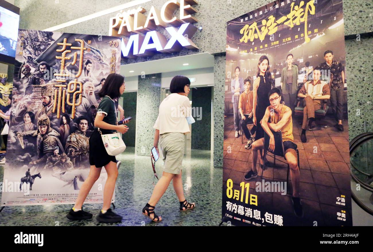 SHANGHAI, CHINA - AUGUST 13, 2023 - People walk past movie posters at the Belle Palace IMAX ...