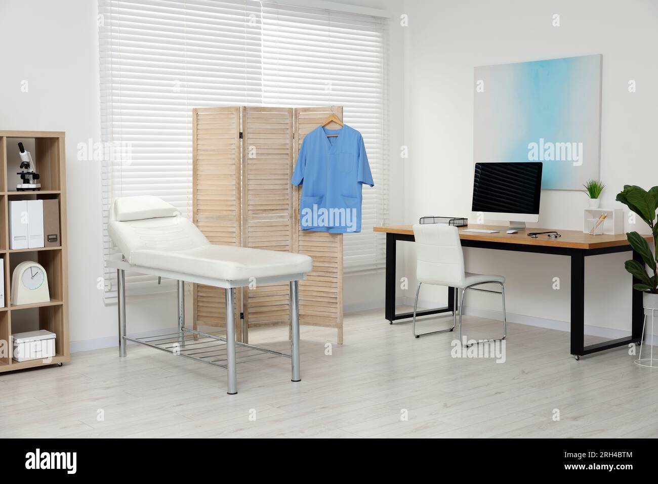 Modern medical office with doctor's workplace and examination table in ...