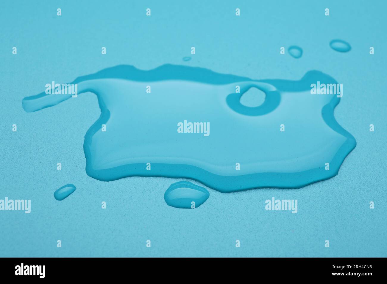 Puddle of water on light blue background Stock Photo - Alamy