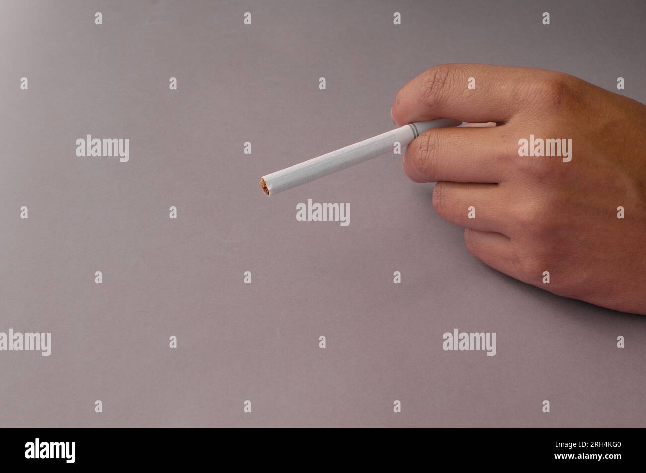 Close-up of a hand holding a cigarette with visible tobacco ...