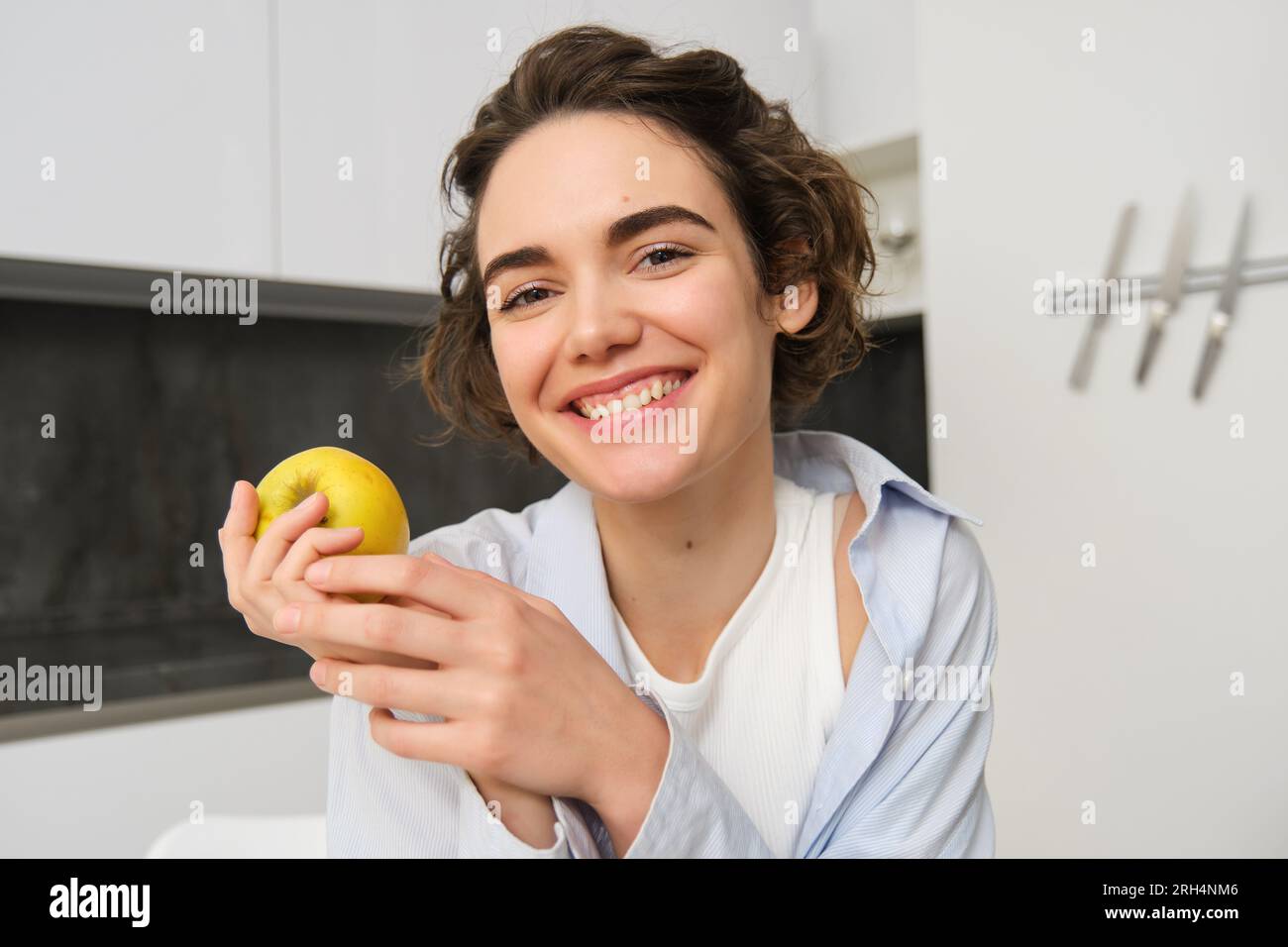 Close up portrait of beautiful smiling woman, eating an apple and ...