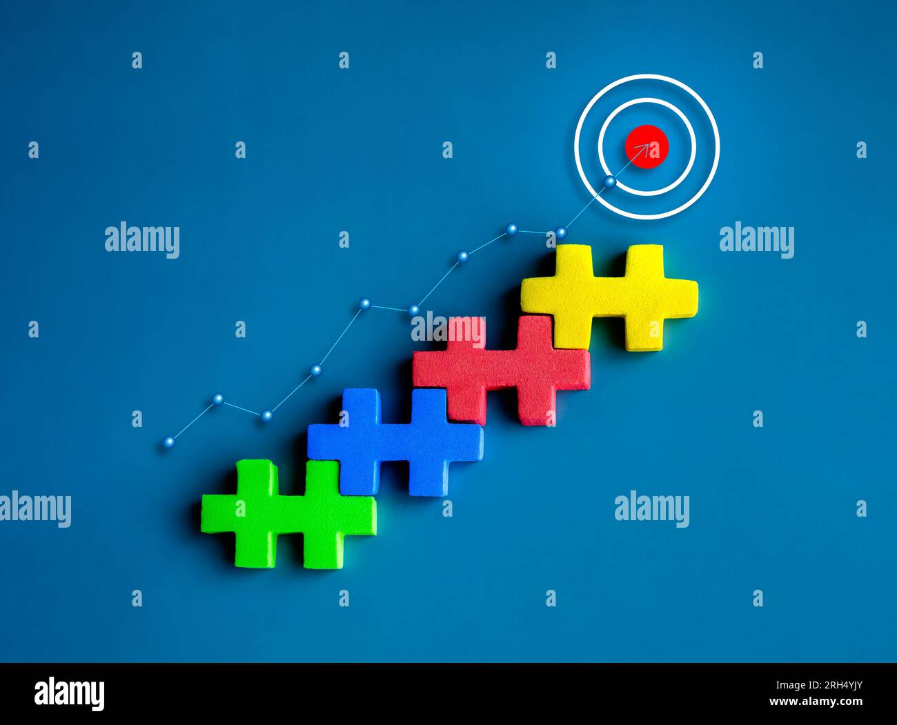 Target icon on top of colorful puzzle blocks as a bar graph chart steps ...
