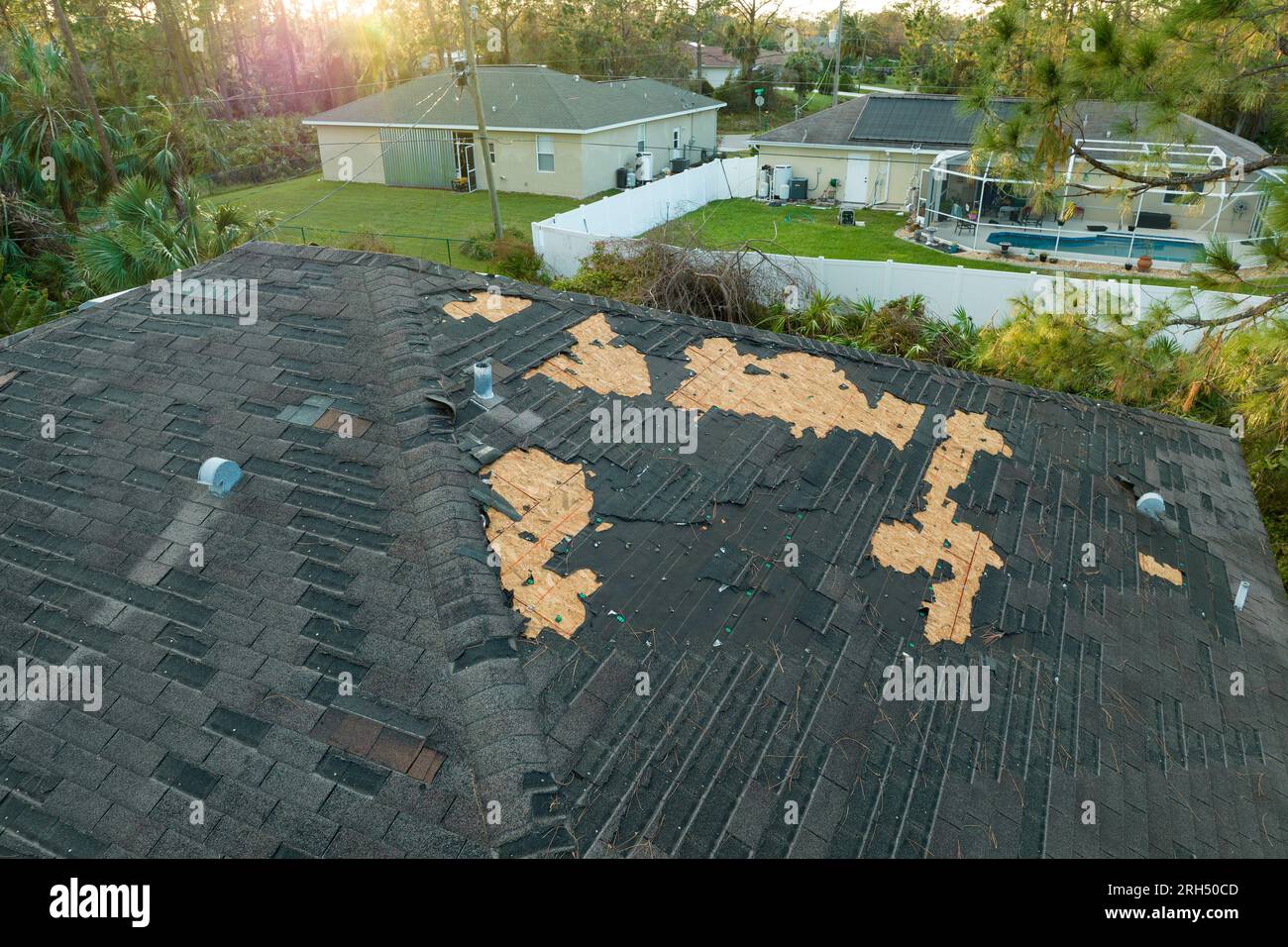 Ruined rooftop in need of repair. Wind damaged house roof with missing ...