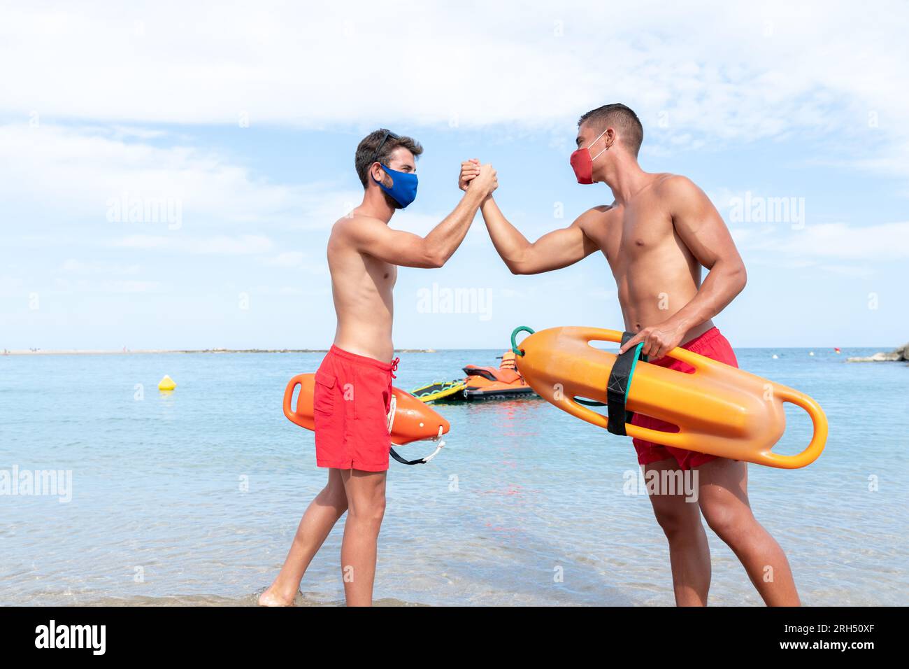 Team of Lifeguards on duty holding a float while shaking hands Stock ...