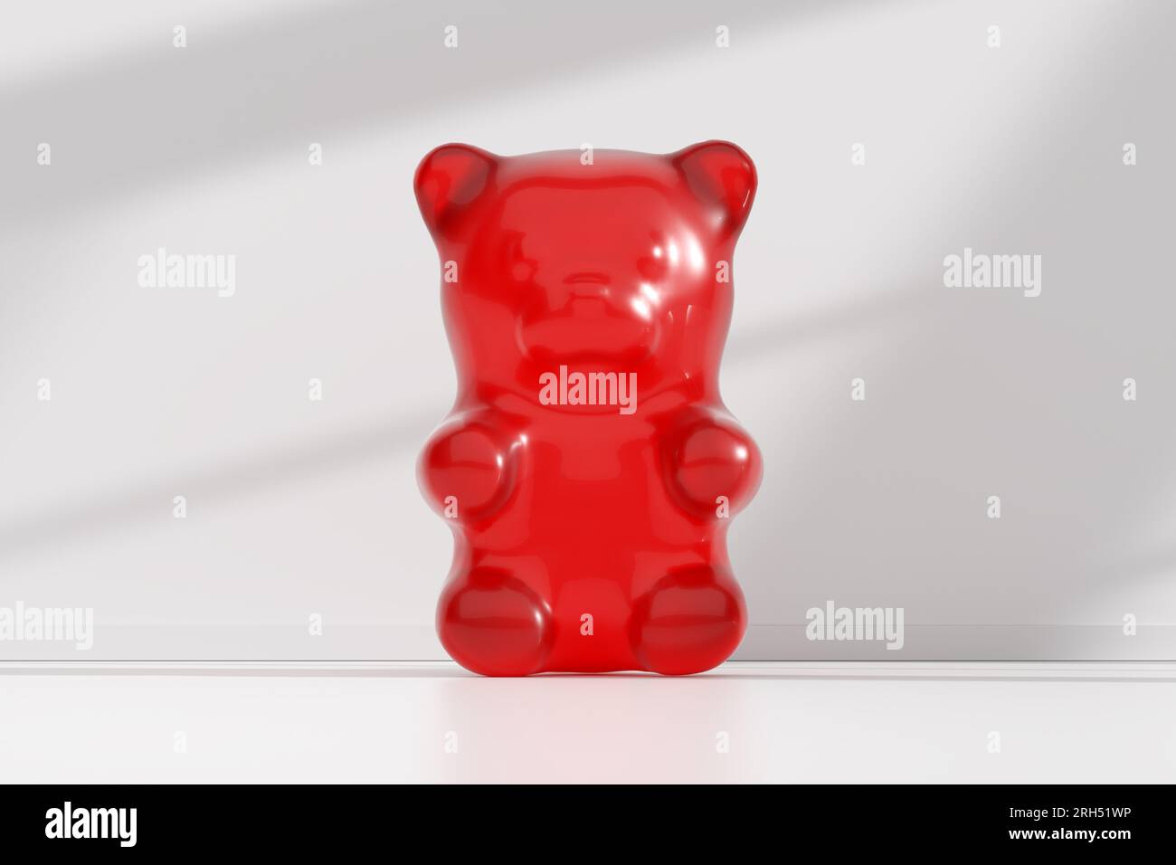 Giant red gummy bear sitting in a house interior with white wall and ...