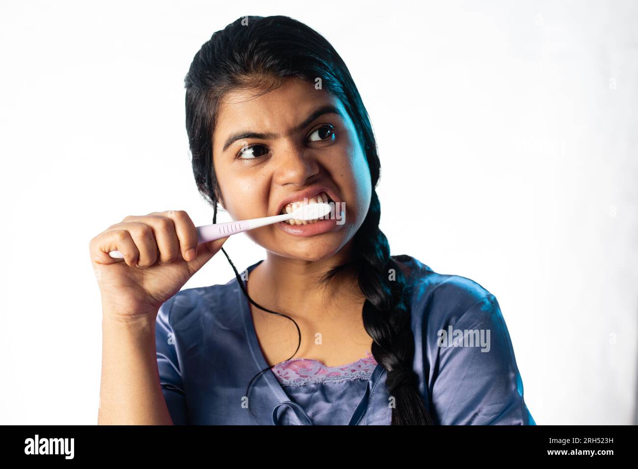 An Indian woman female girl brushing teeth on white background and ...