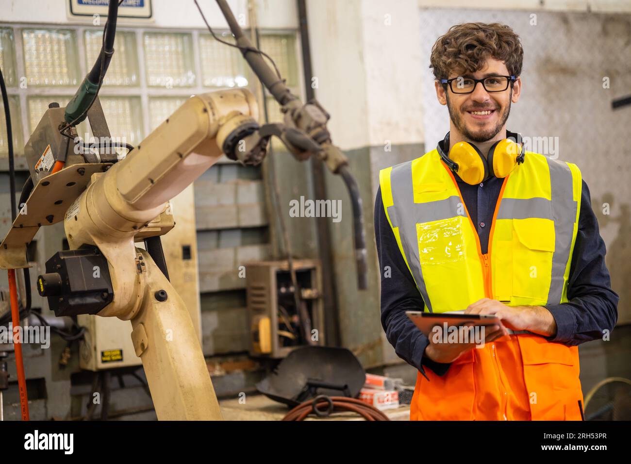 portrait happy young caucasian male worker robot arm machine operator ...