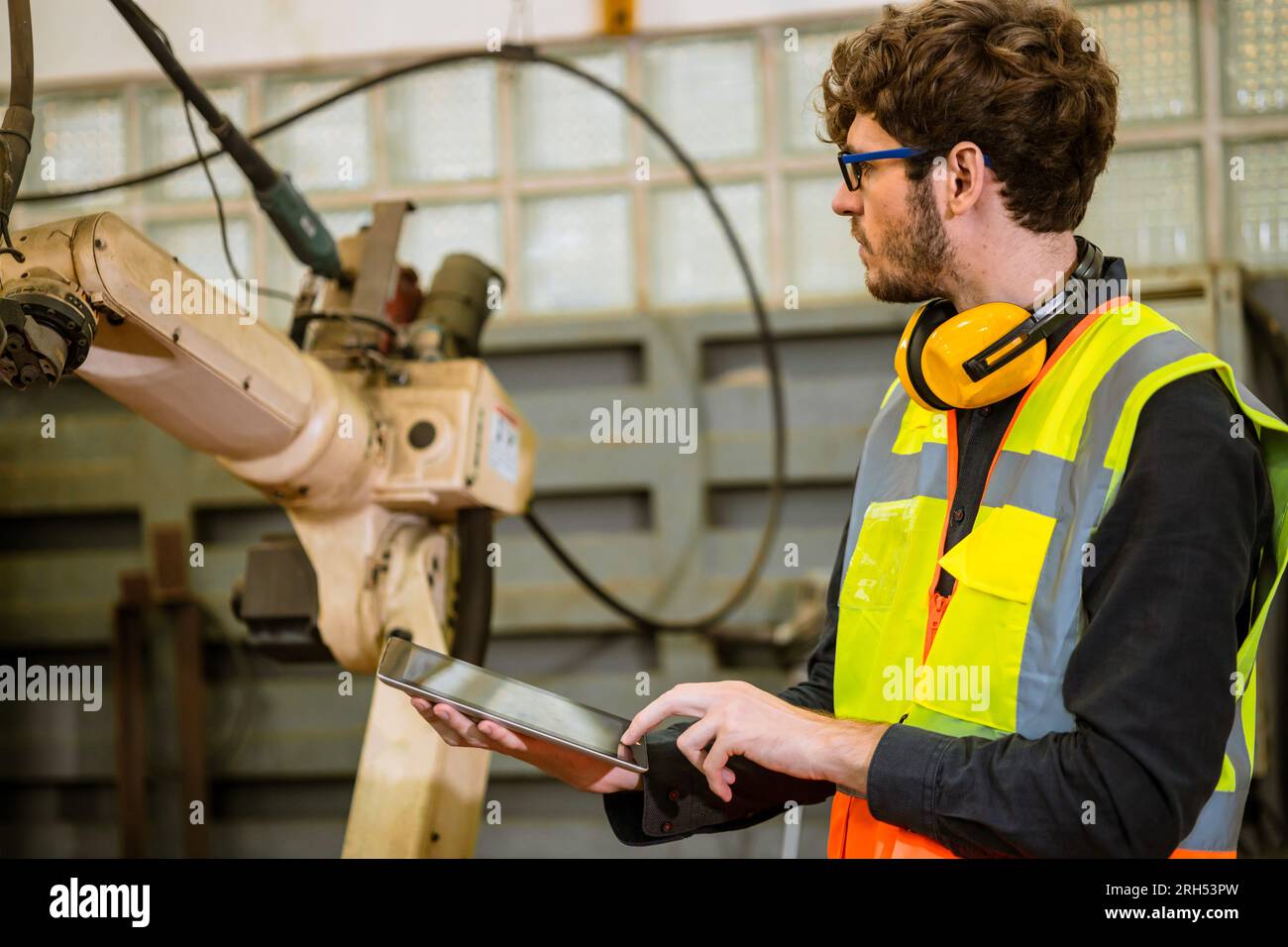 smart young engineer work service maintenace programming automatic robot welding machine in ...