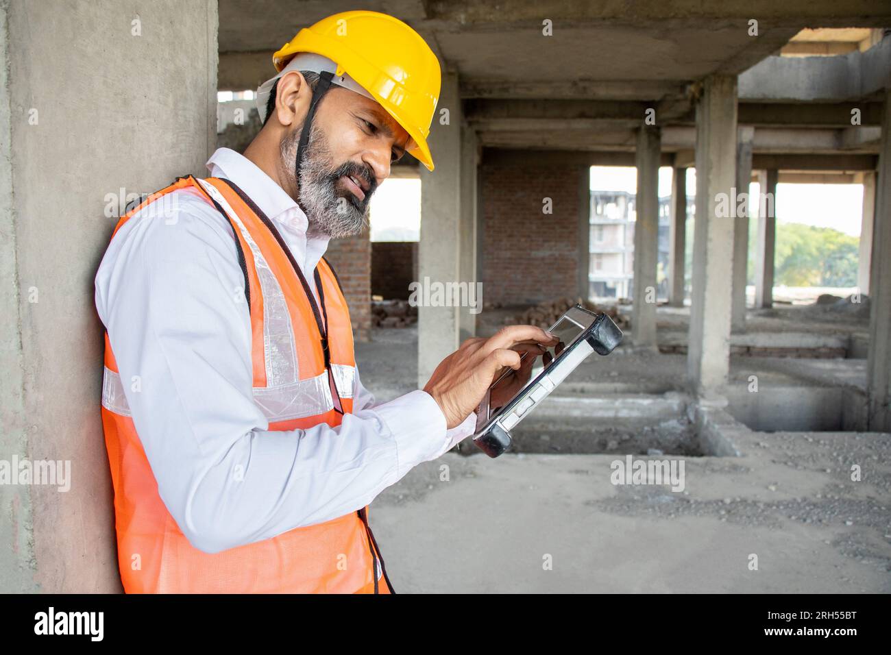 Mature Indian male civil engineer or architect wearing helmet and vest ...