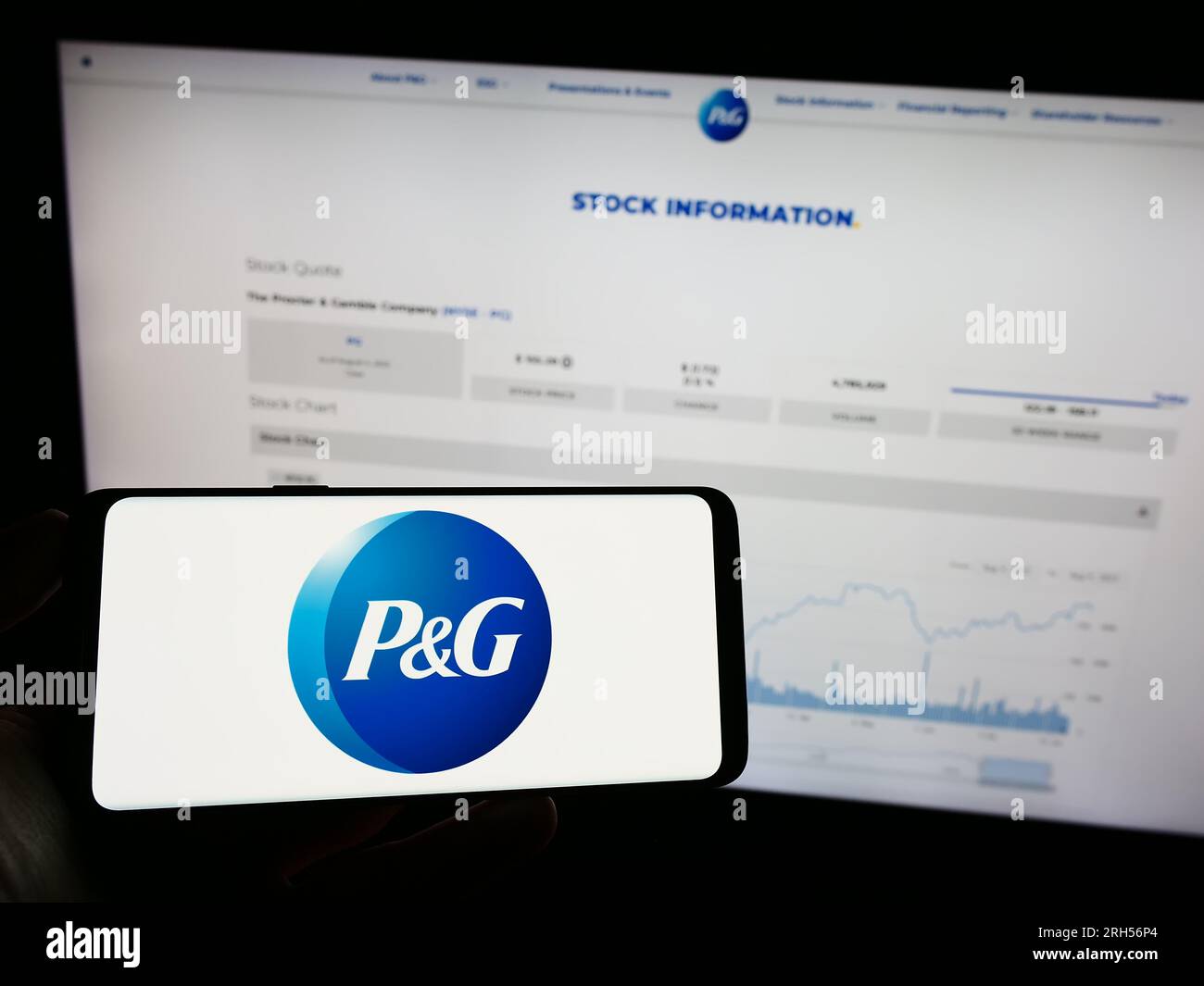 Person holding mobile phone with logo of American business The Procter Gamble Company on screen ...