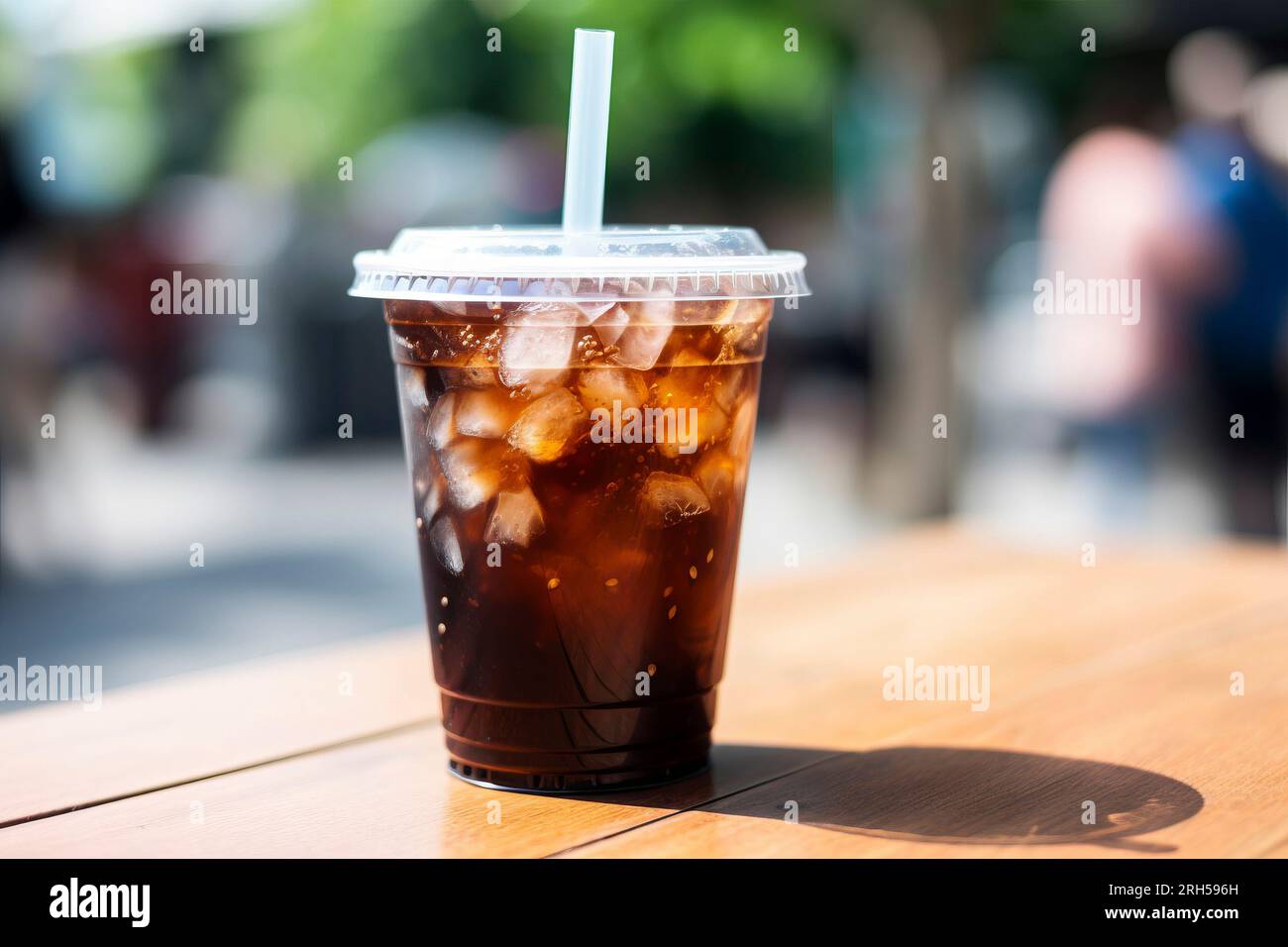 A plastic glass filled with cola and ice cubes, representing the ...