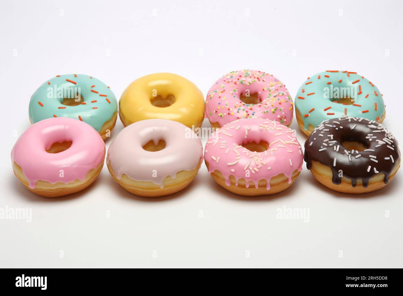 Colorful donuts showcased in a delicious array against a pristine white ...