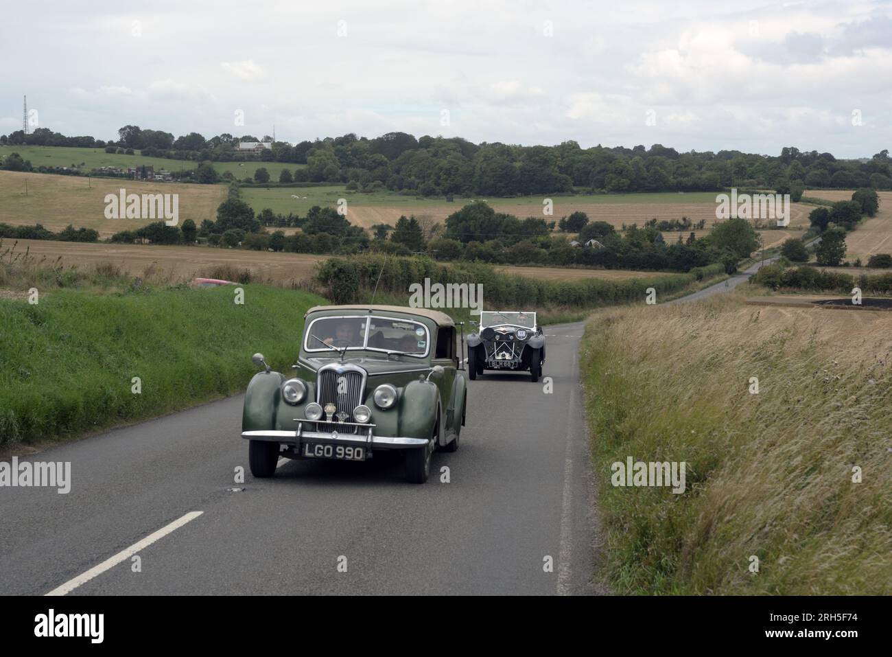 A 1950 Riley RMD Drophead Coupe leads a 1933 Riley 9 Lynx along a hilly ...