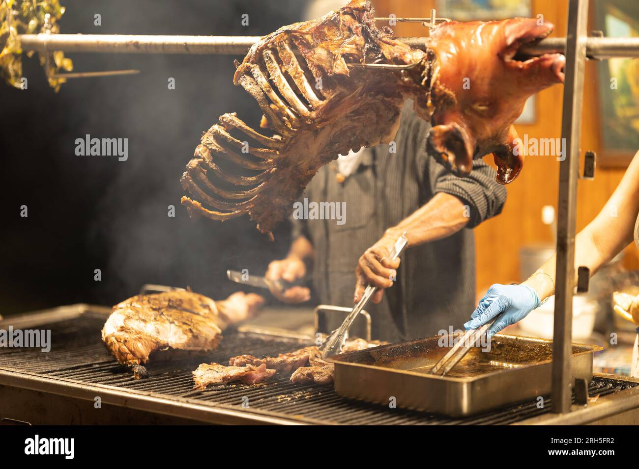 Roasted whole pigs on fire - grilled pig on skewer Stock Photo - Alamy