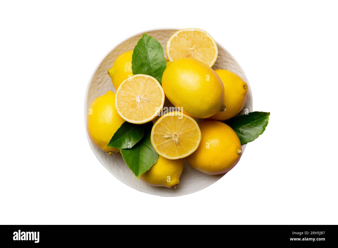 Fresh cutted lemon and whole lemons over round plate isolated on white ...