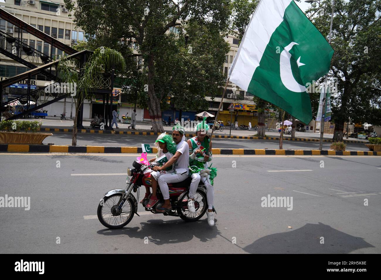 Two men and a youngster wear turbans of national colors and ride a ...