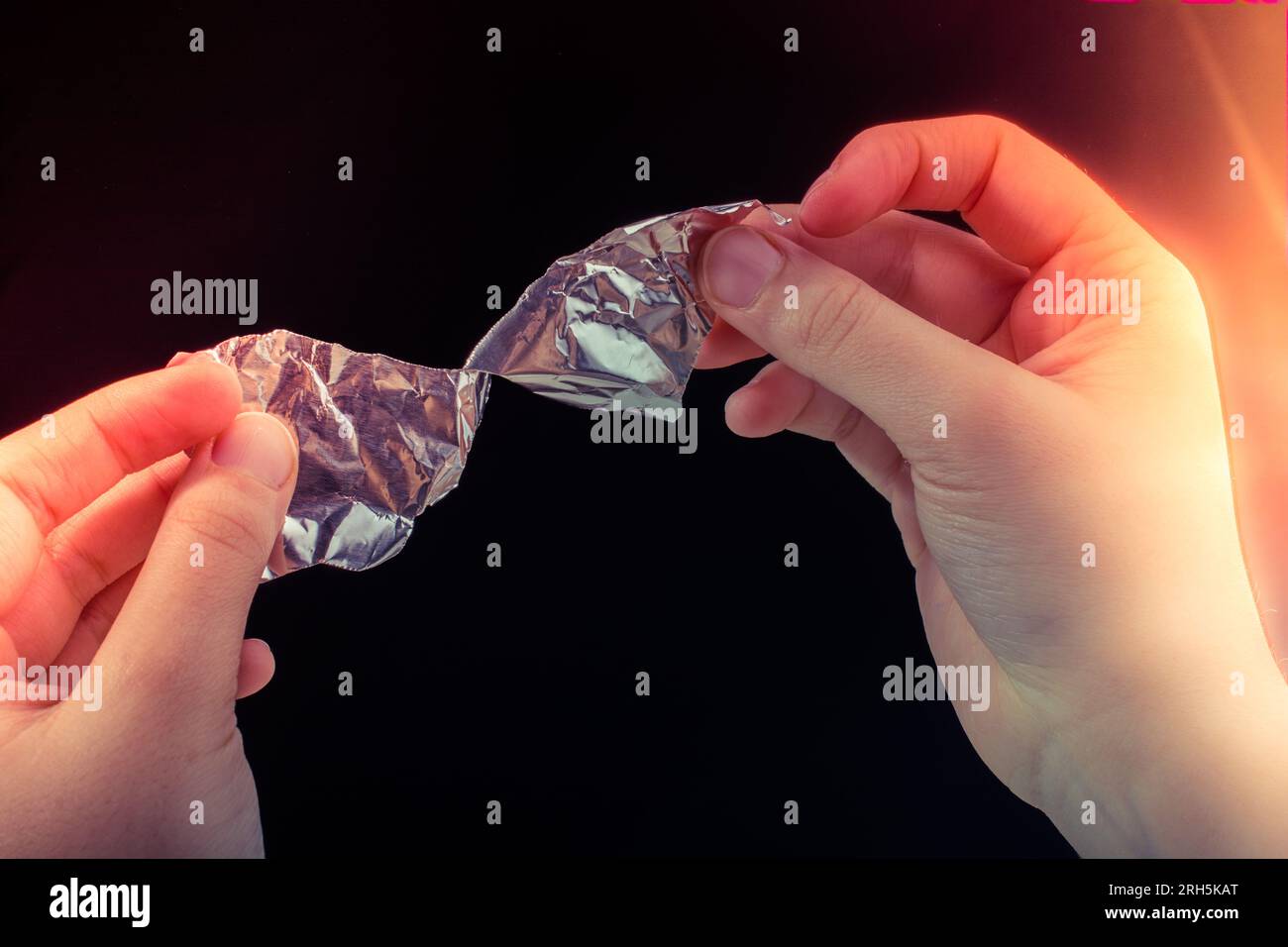 Hand tearing a heart shaped aluminium foil on wooden background Stock ...