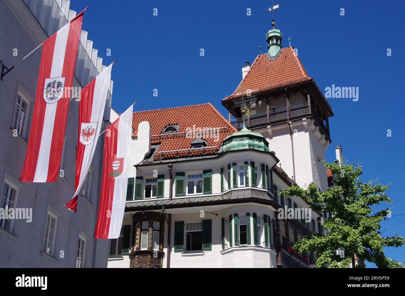 Traditional Austrian Buildings with tyriolean banners and blue sky ...