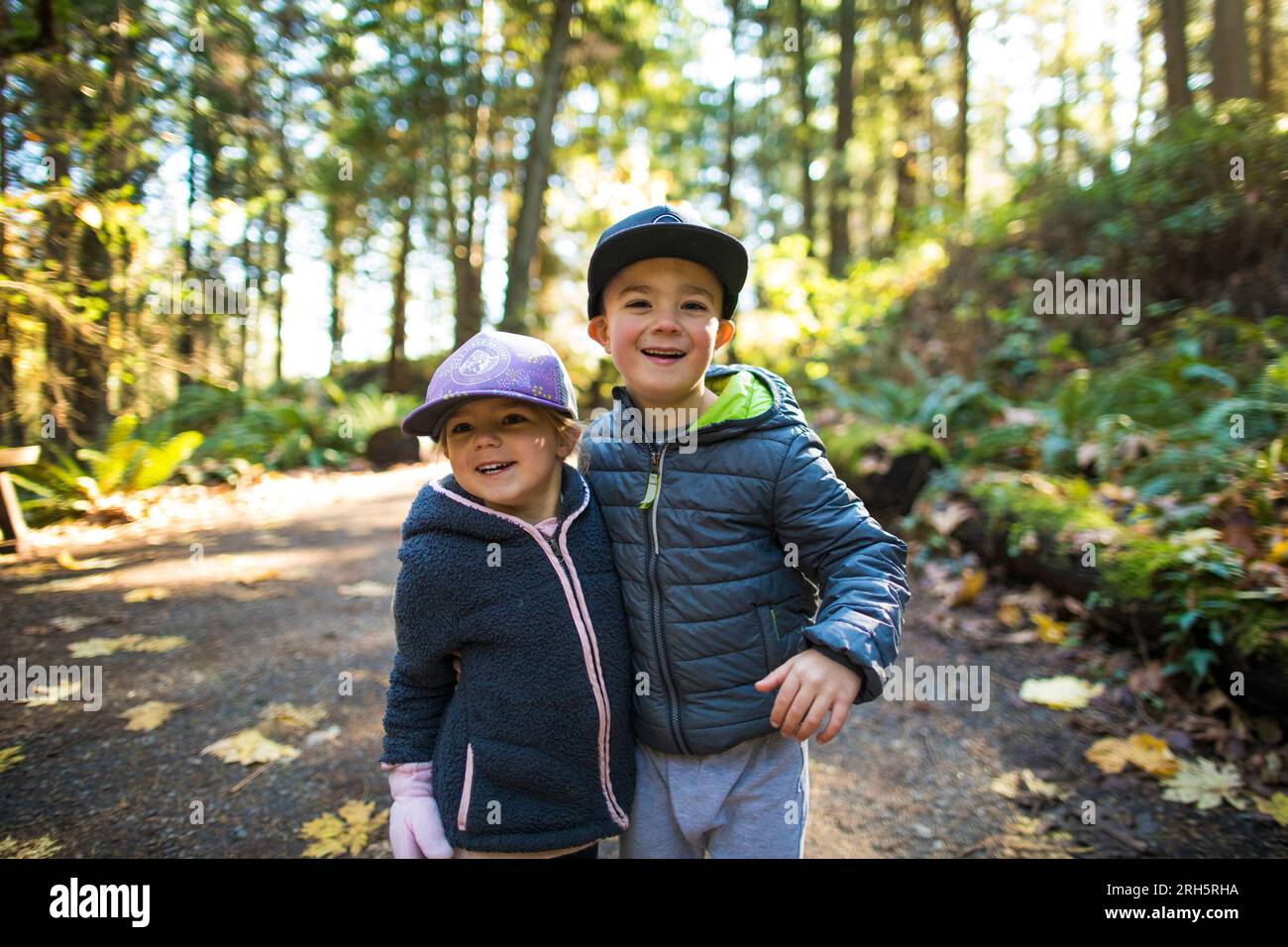 Portrait of smiling boy and girl exploring nature, embracing Stock ...