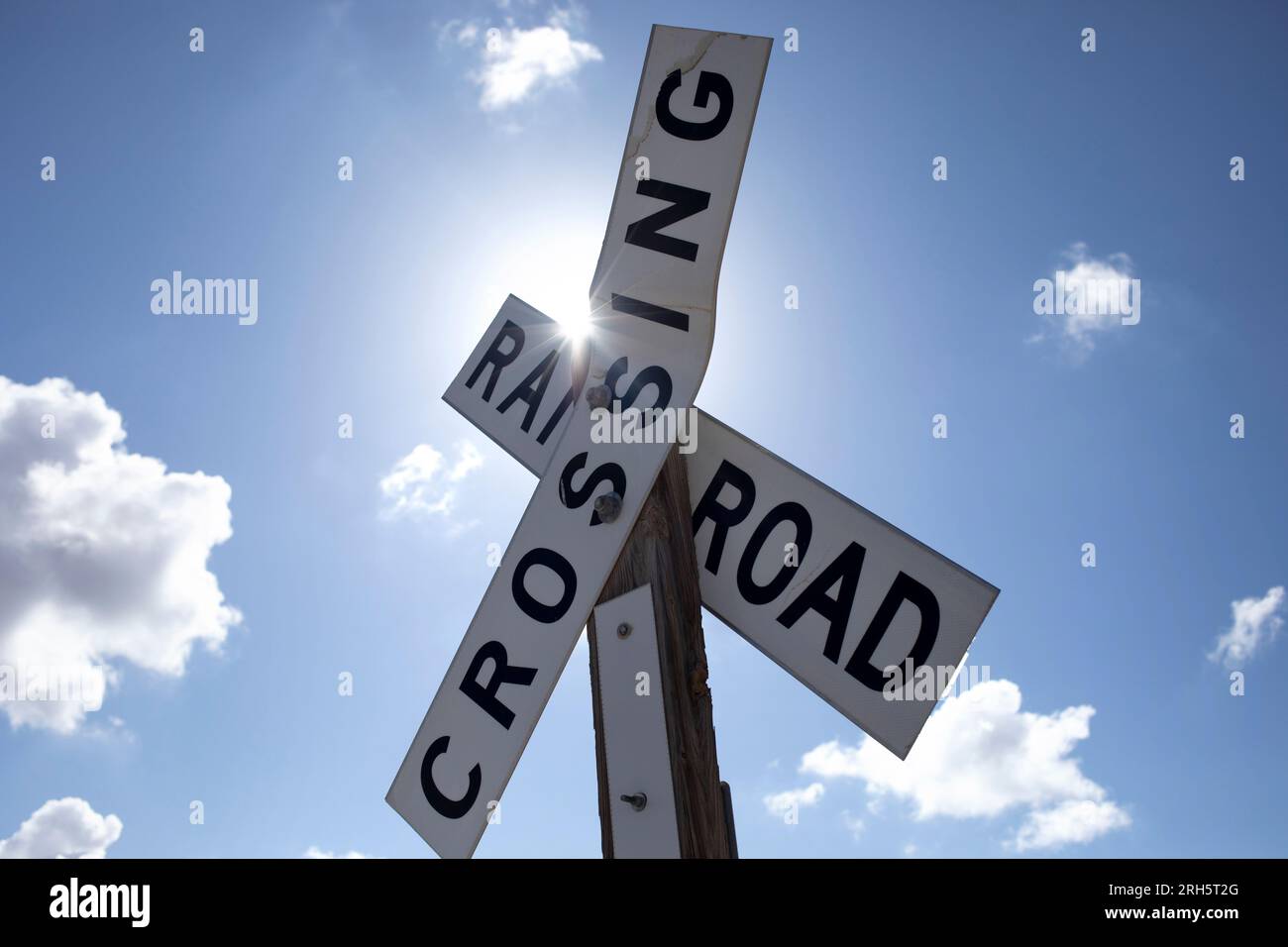 Railroad crossing cross bucks sign backlit Stock Photo - Alamy